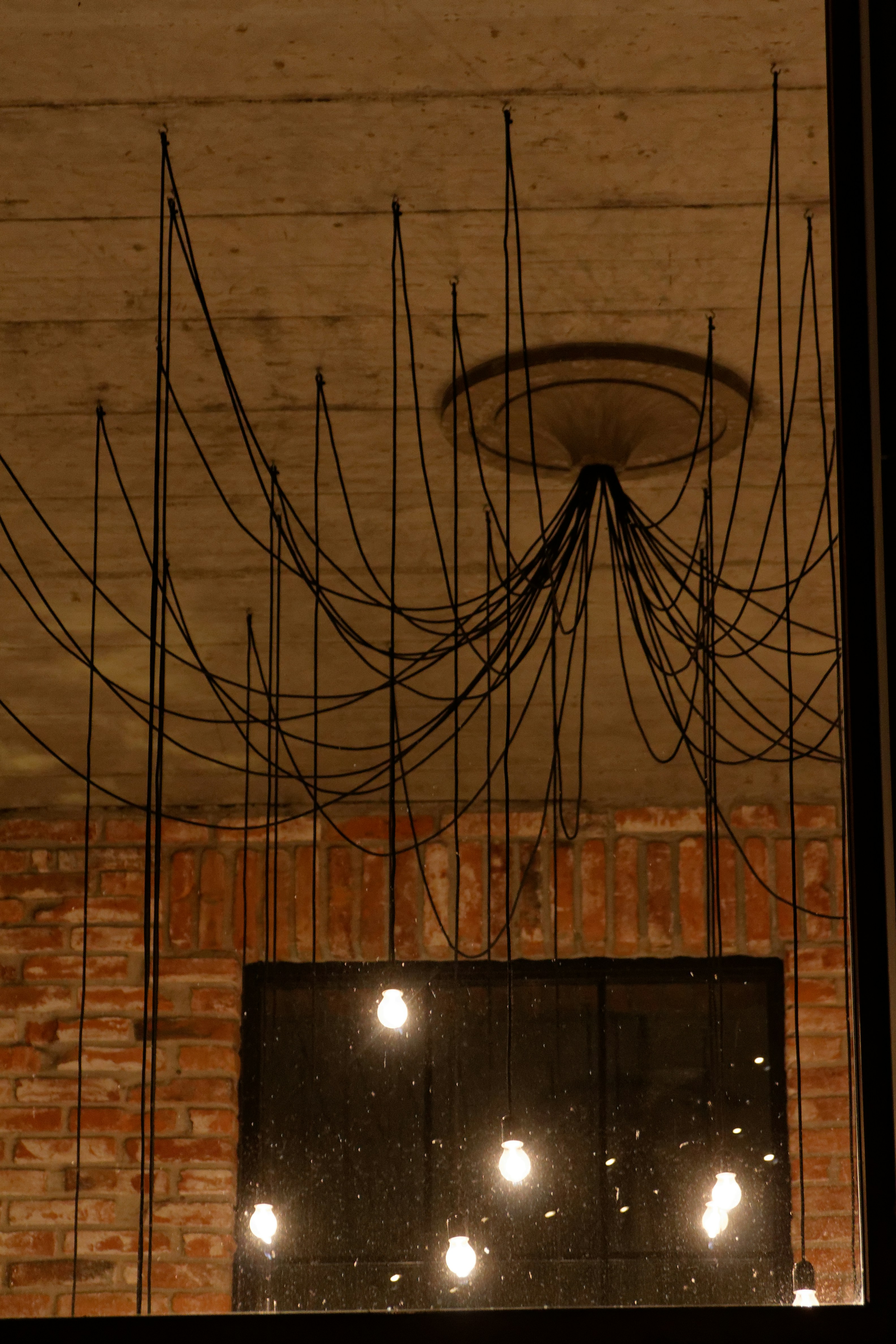Amber Orbs and a Web of Wires Over a Brick Loft