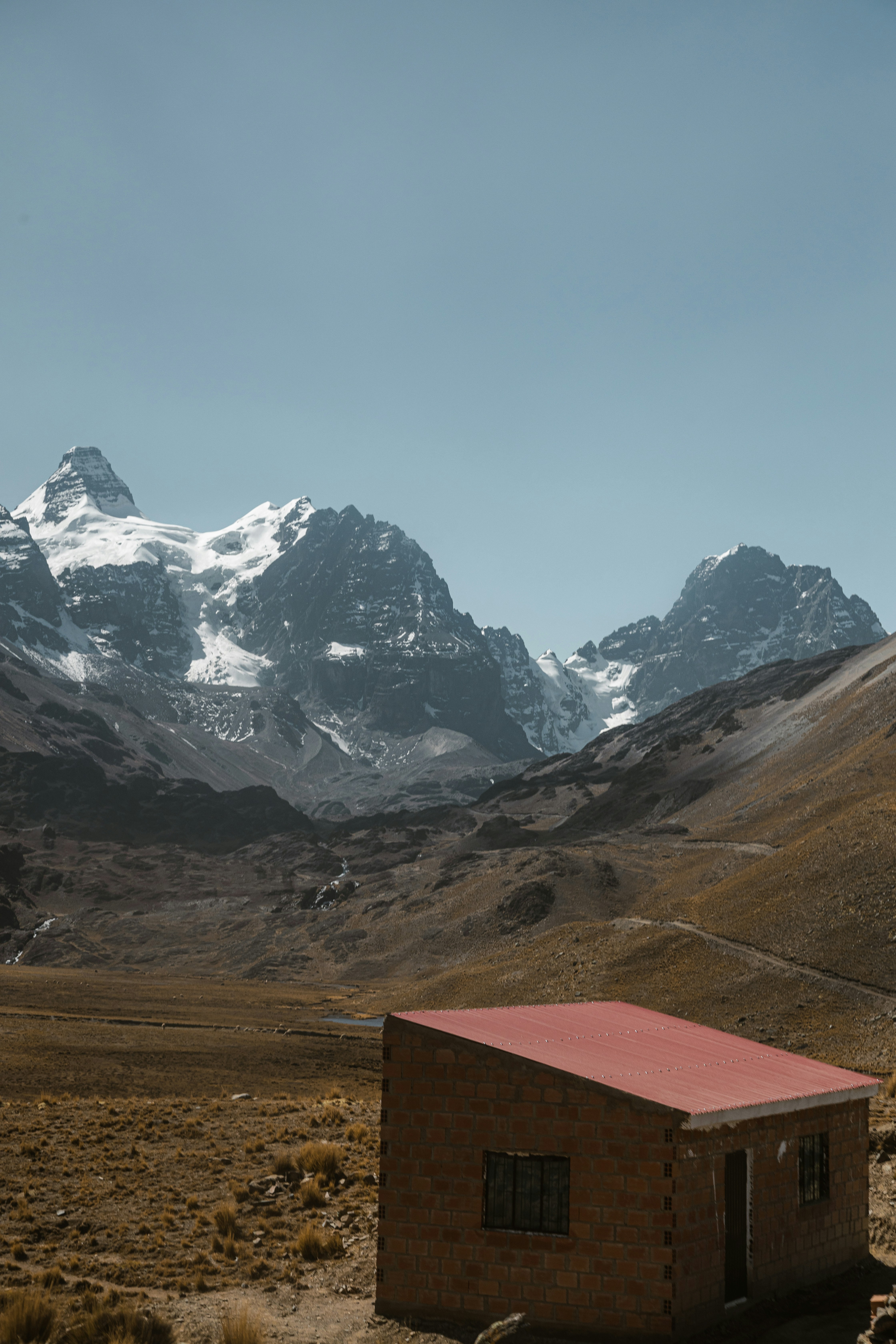 Red-Roofed Cabin at the Foot of Snowbound Peaks