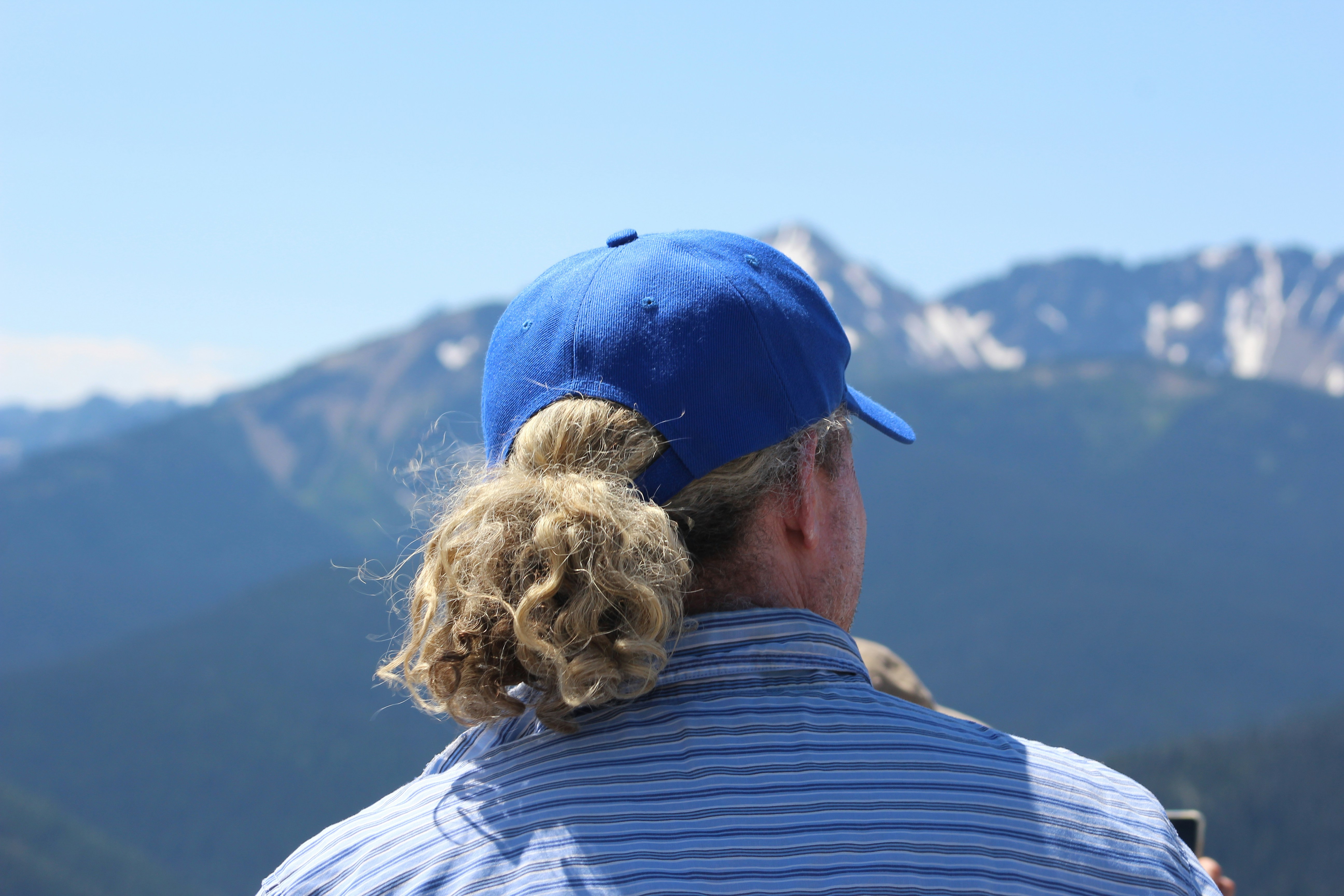 Blue-Capped Observer Framed by a Majestic Alpine Backdrop