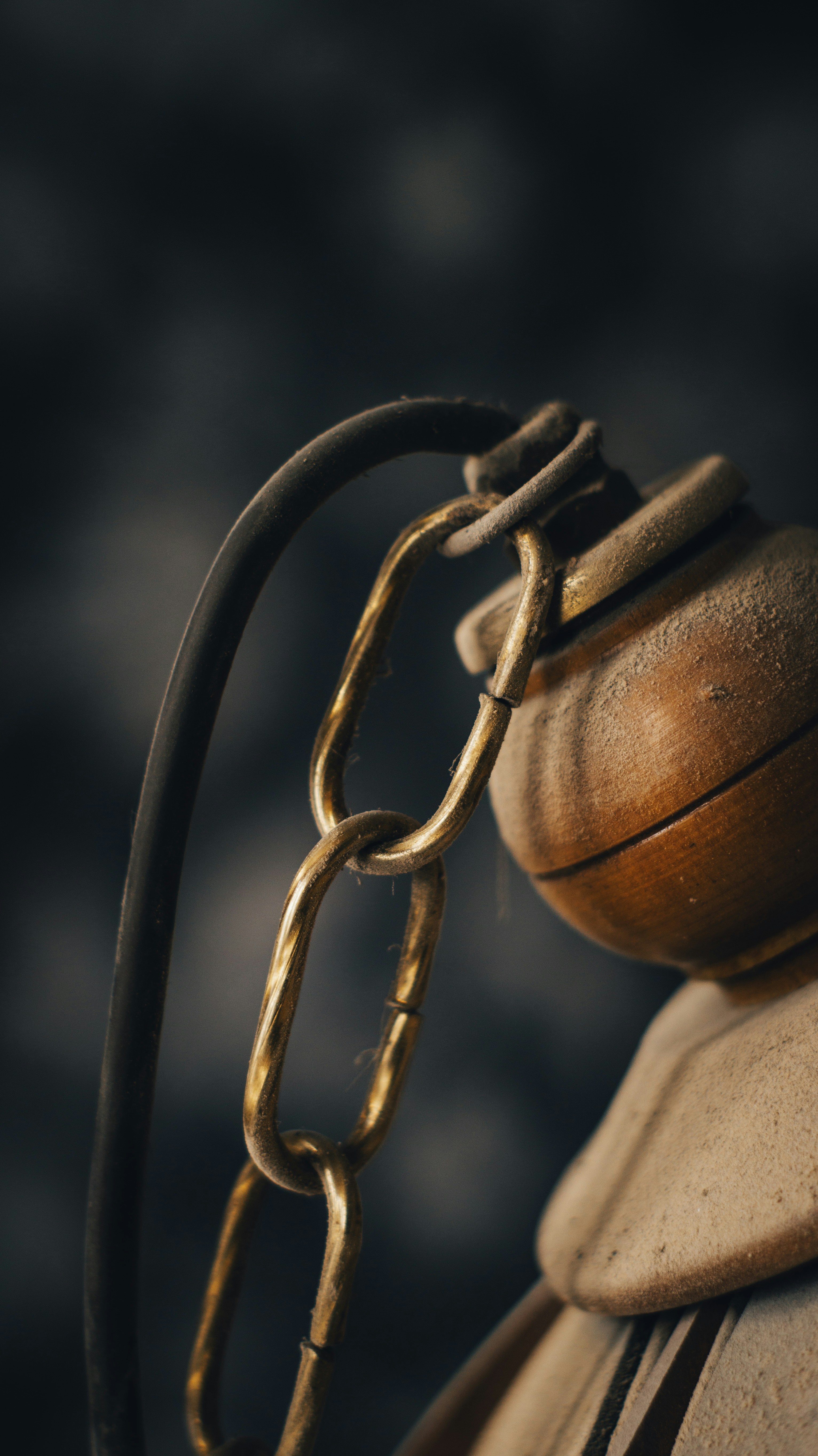 Rust and Ring: A Close-Up of a Weathered Chain on a Wooden Pendant