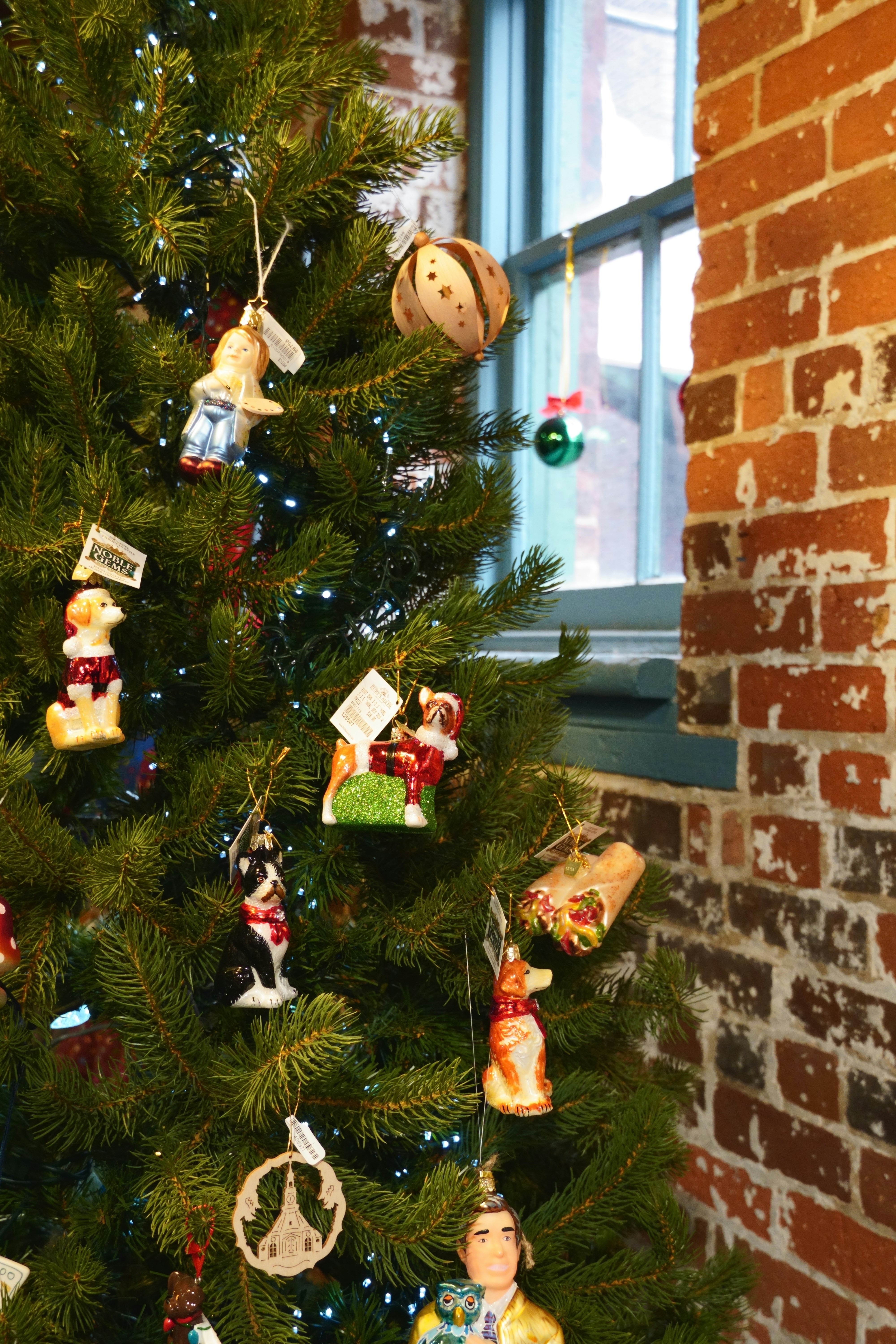 Ornamented Christmas Tree Sprung with Tiny Characters by a Brick Window