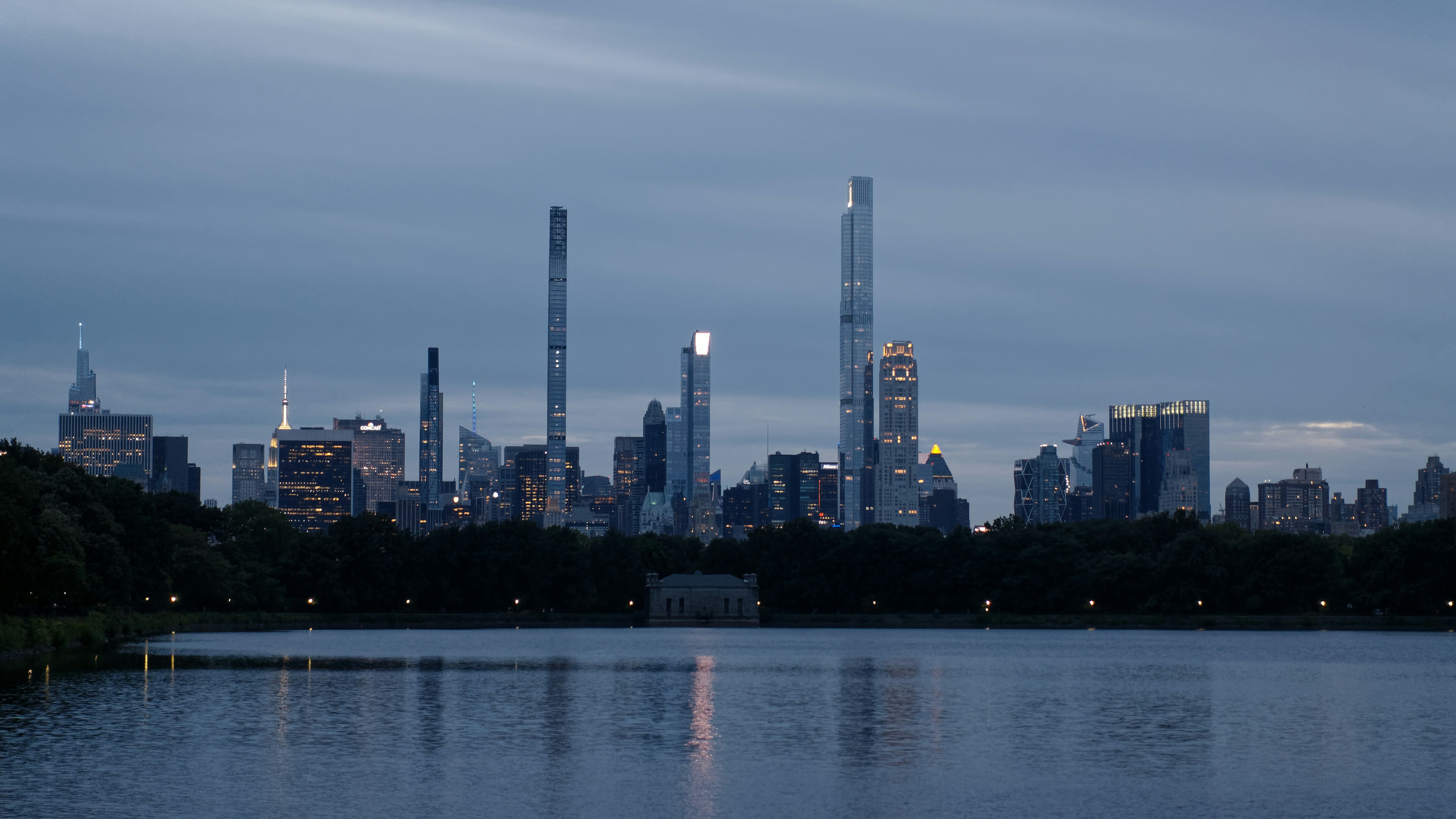 Blue-hour skyline mirrored on a quiet lake