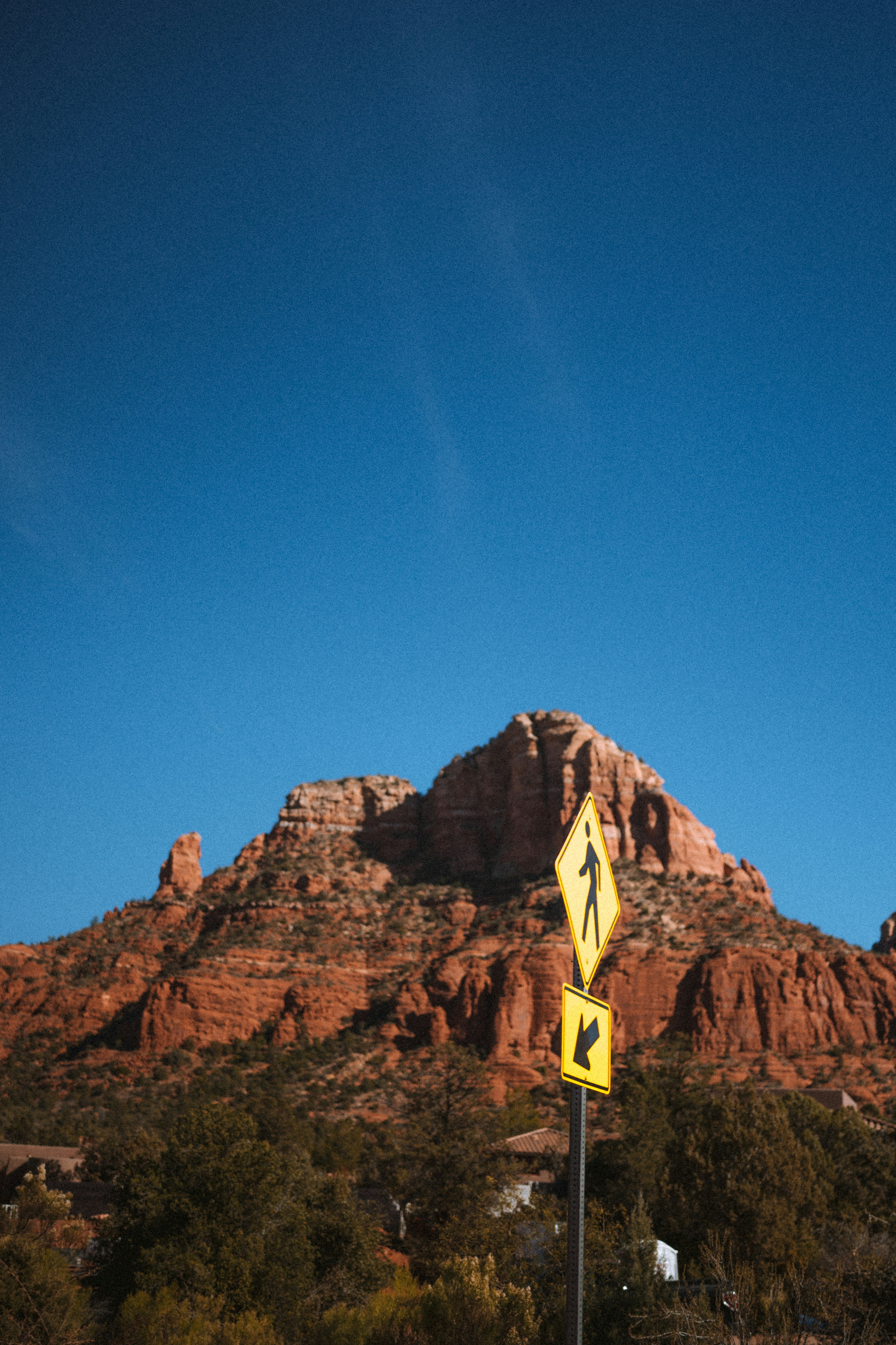 Crimson Rock Ridge Under a Pristine Blue Sky, with a Foreground Signpost