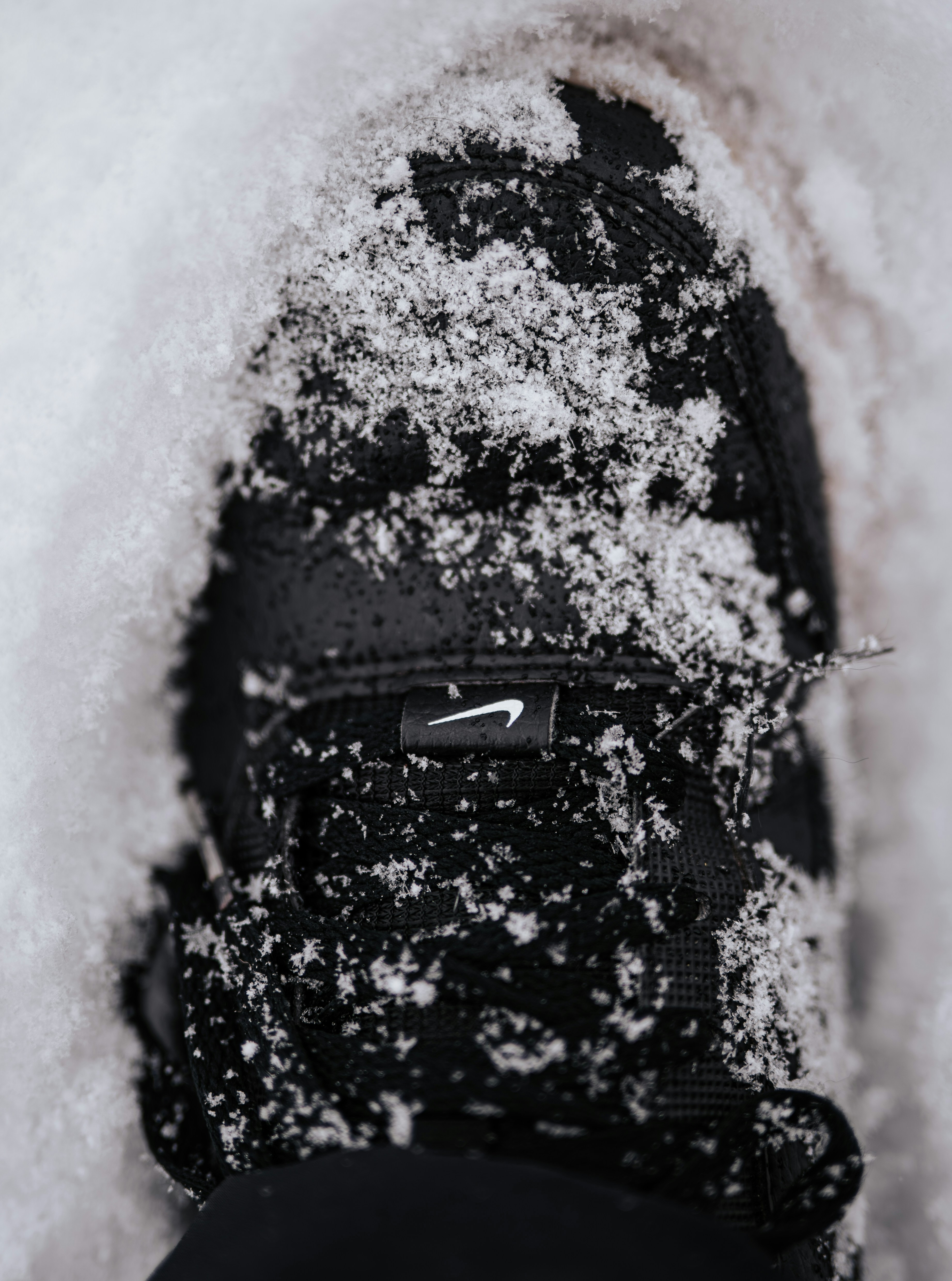 Frosted Focus: snow-dusted Nike sneaker strap peeks through the snow