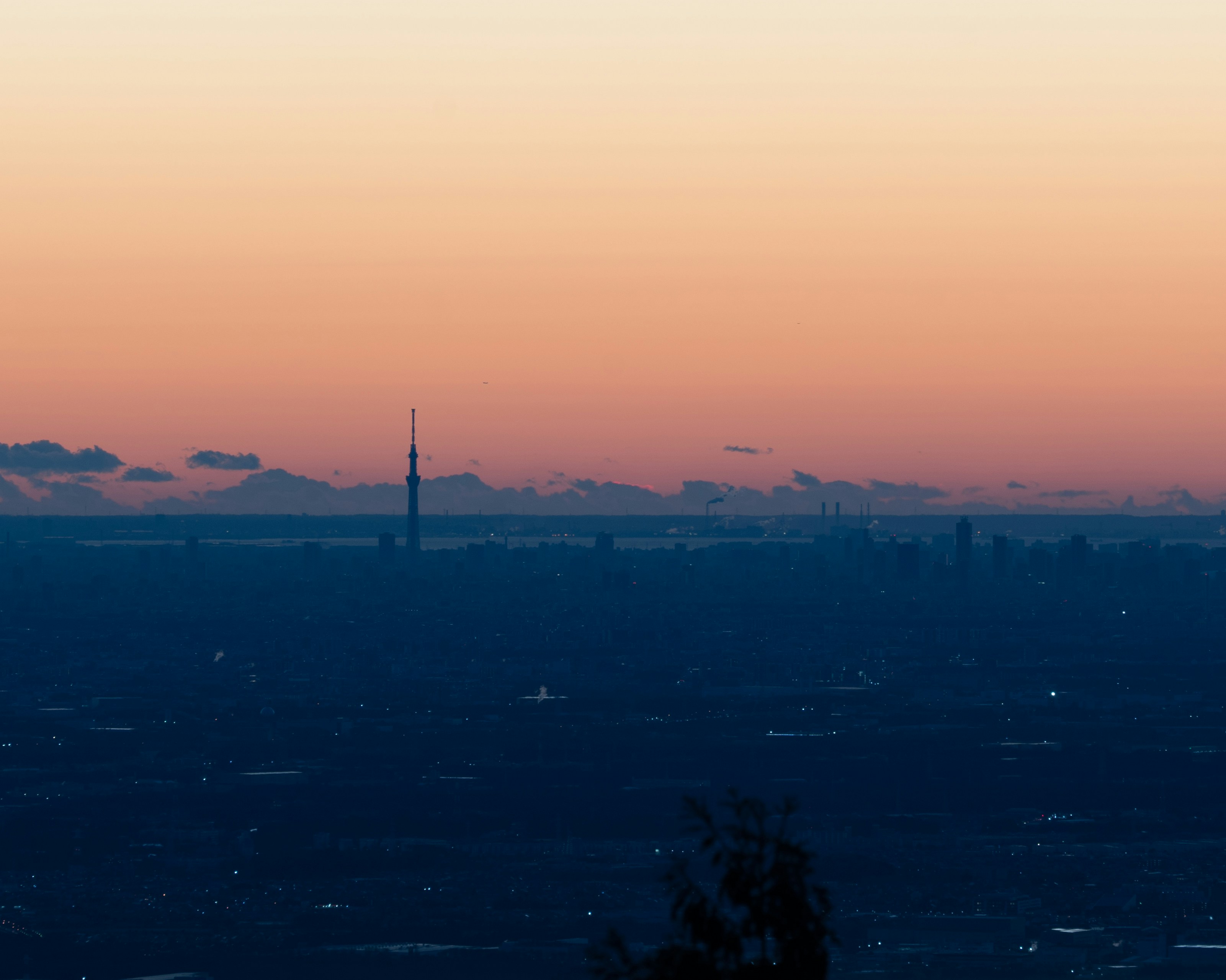 Dawn Sentinel Over the City: Tower Silhouette on a Peach-to-Blue Horizon