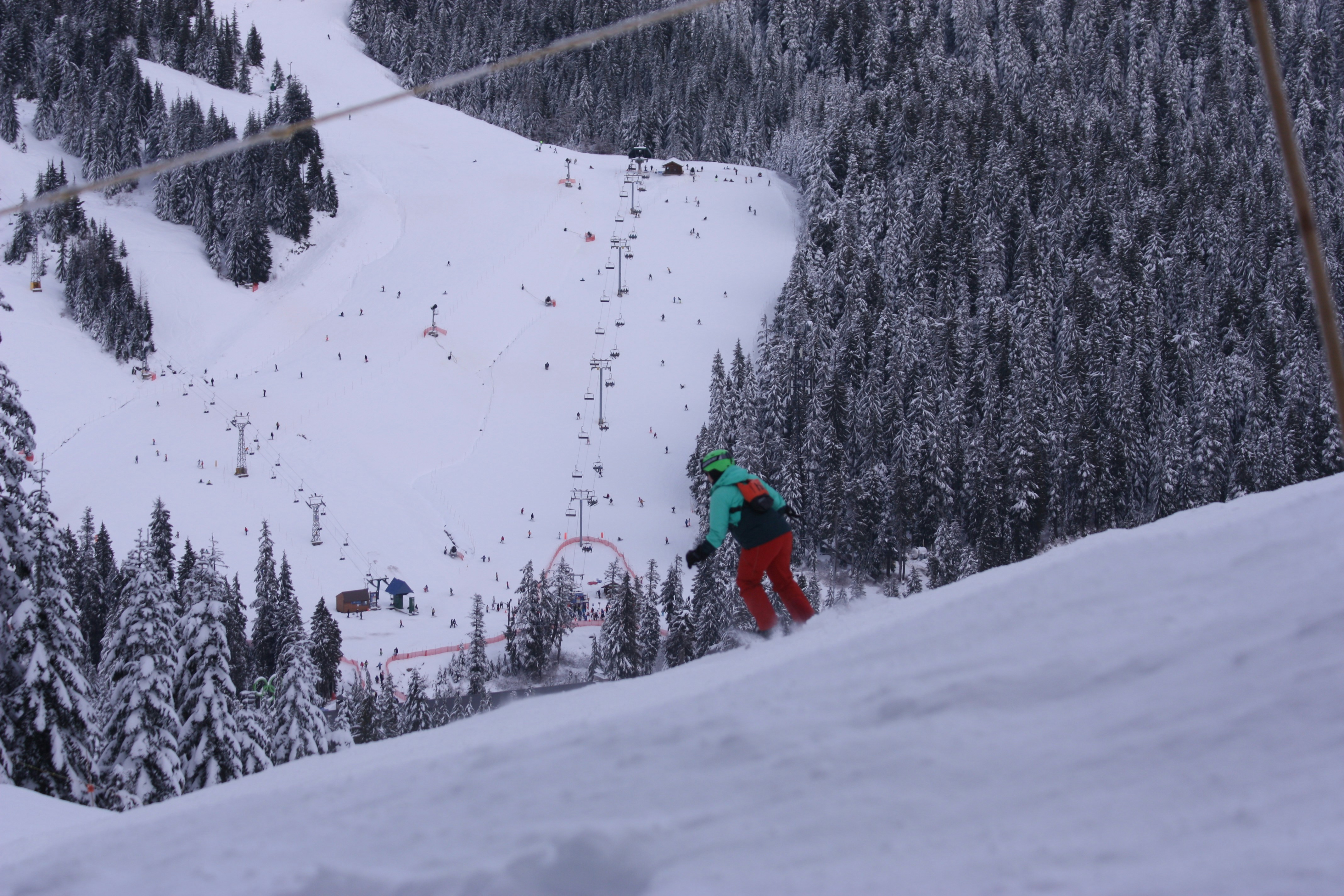 Powder Bound: Skier in Teal Threads a Snow-Draped Alpine Slope Under a Lift
