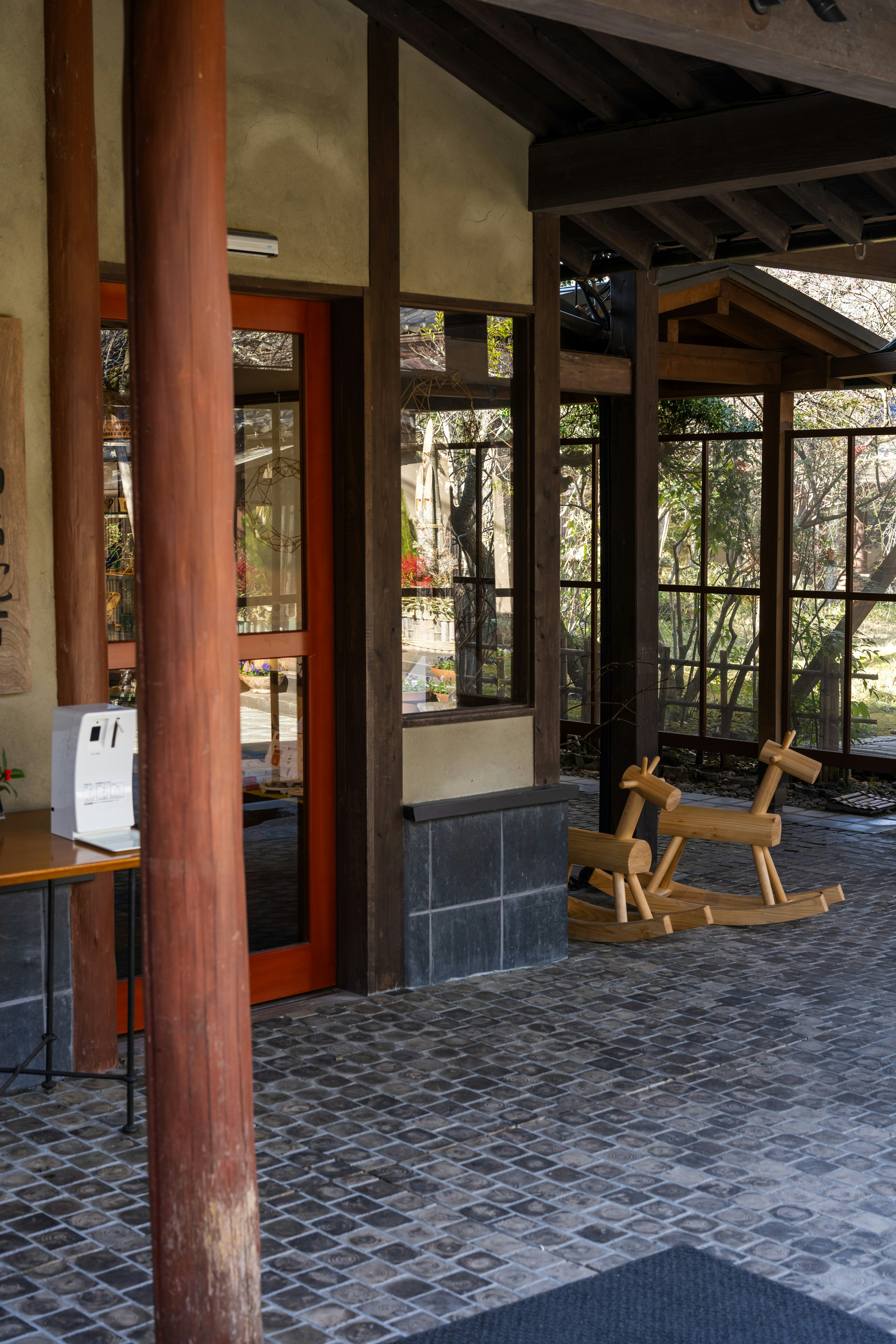 Timber-Frame Entrance: Red Door Framing a Cobblestone Courtyard