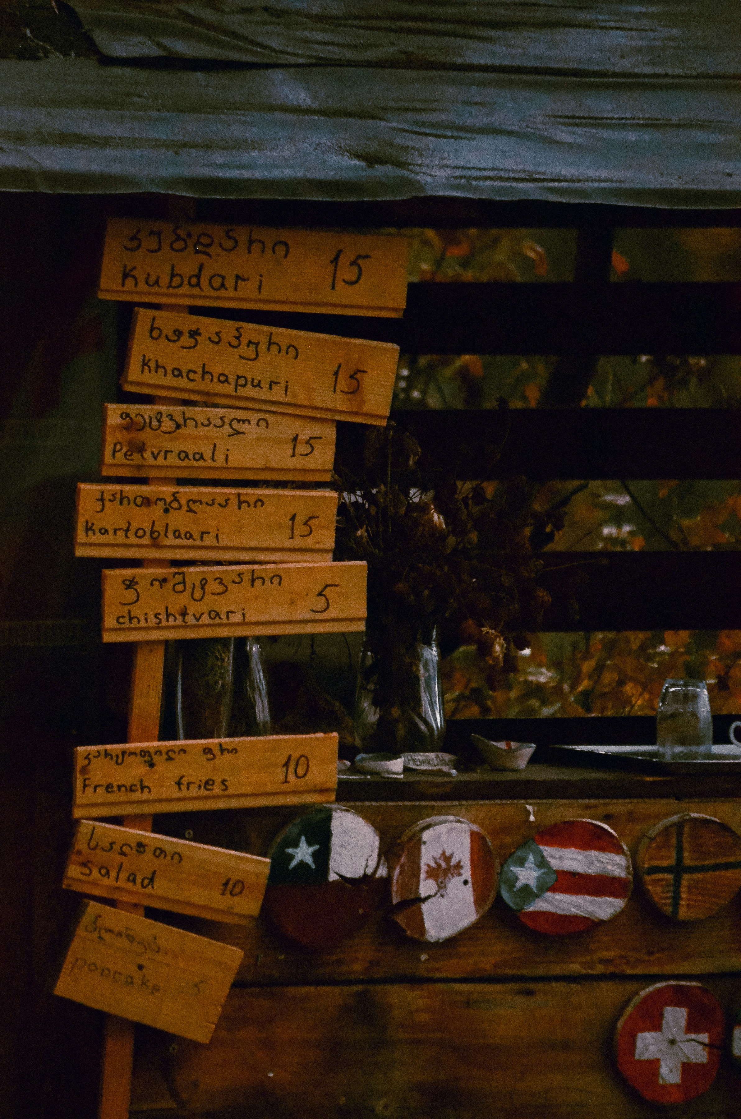Rustic Menu Plaques and Painted Circles in a Dim Café Stall
