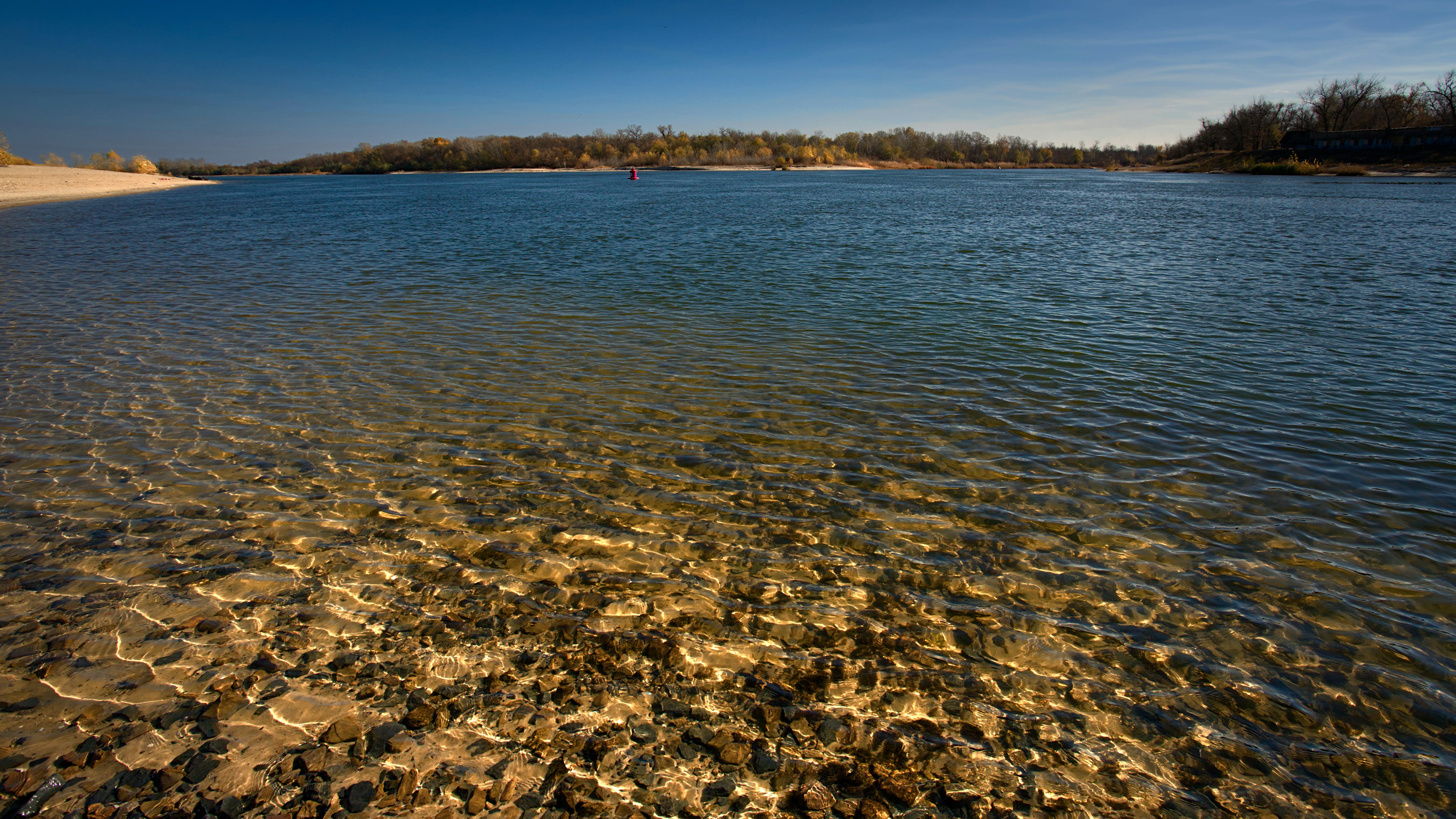 Glassy Horizon: A Lone Boat Drifts Over Clear Coastal Waters