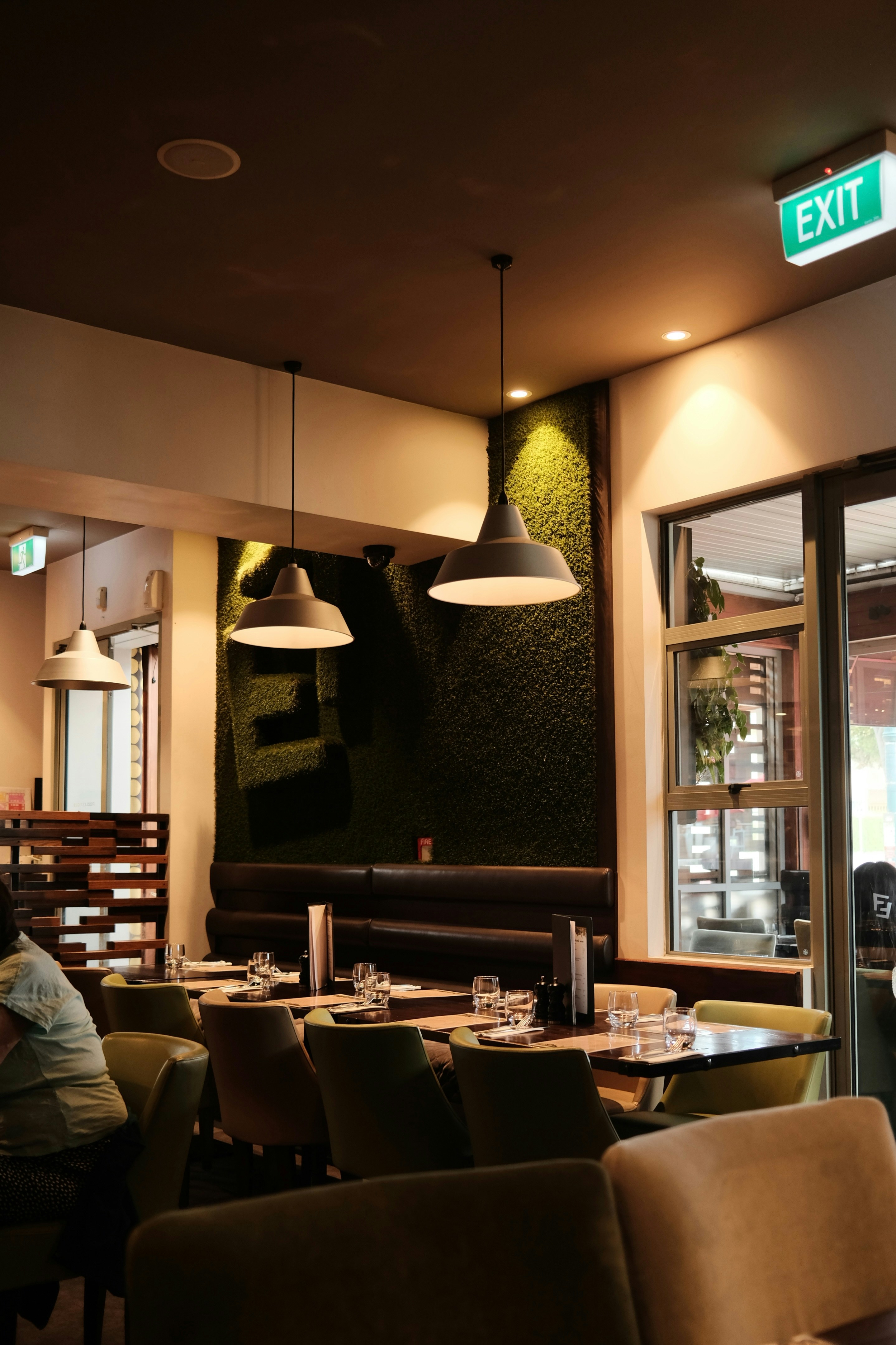 A restaurant with tables and chairs and a exit sign photo – Free ...