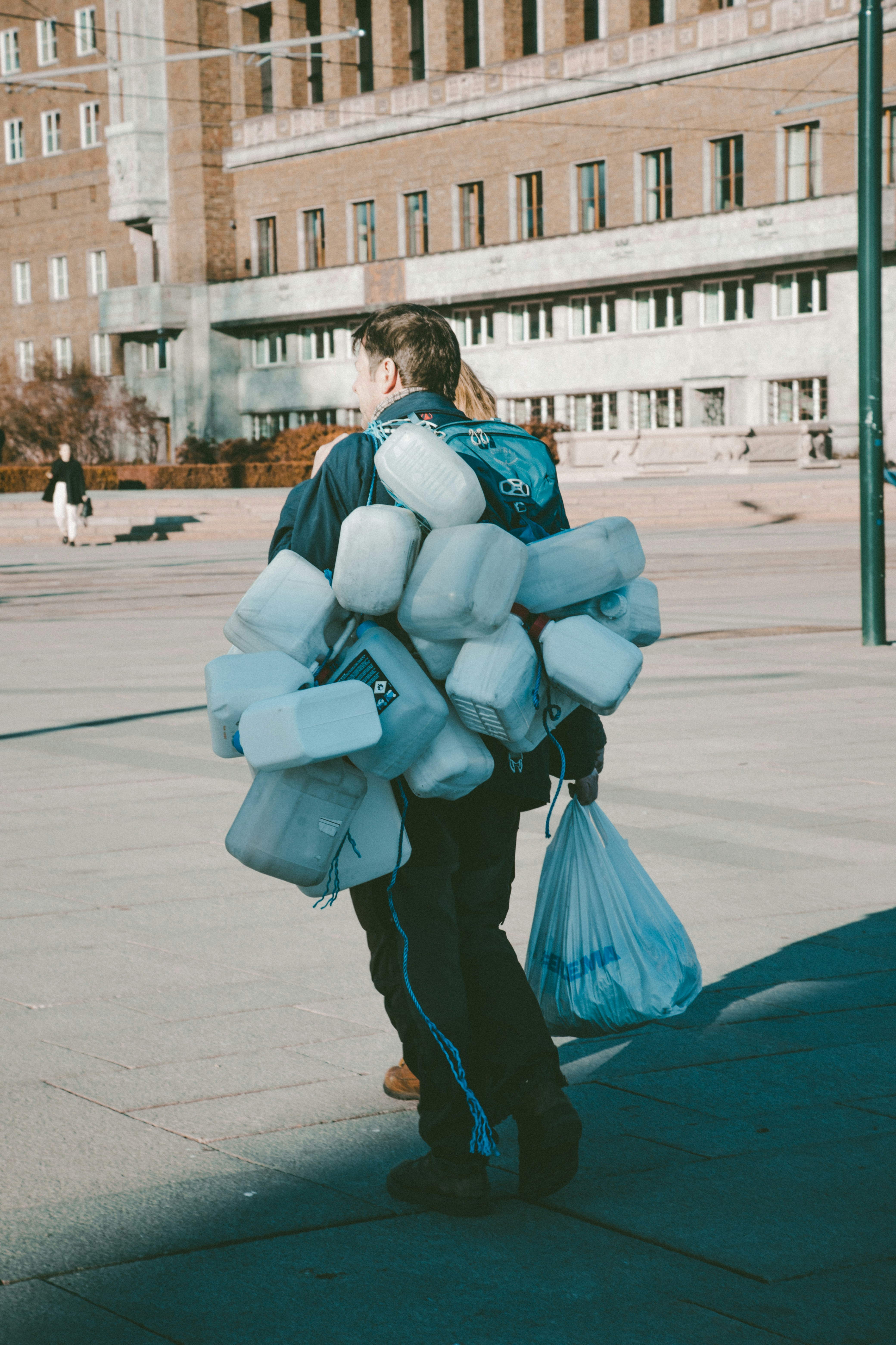 A man walking down a street carrying a bag of stuff photo – Free 2024 ...