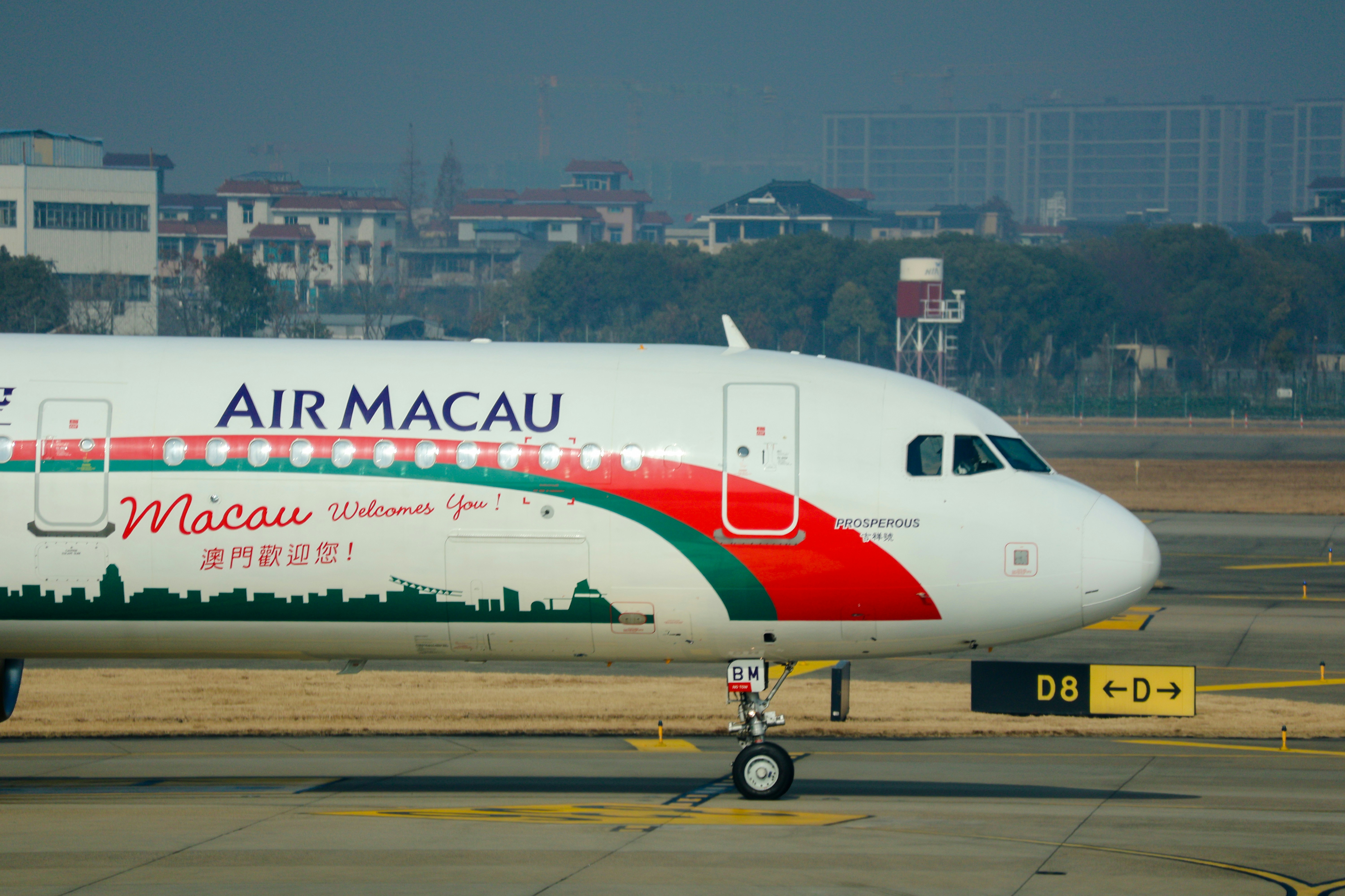 A large air macau jet sitting on top of an airport tarmac photo – Free ...