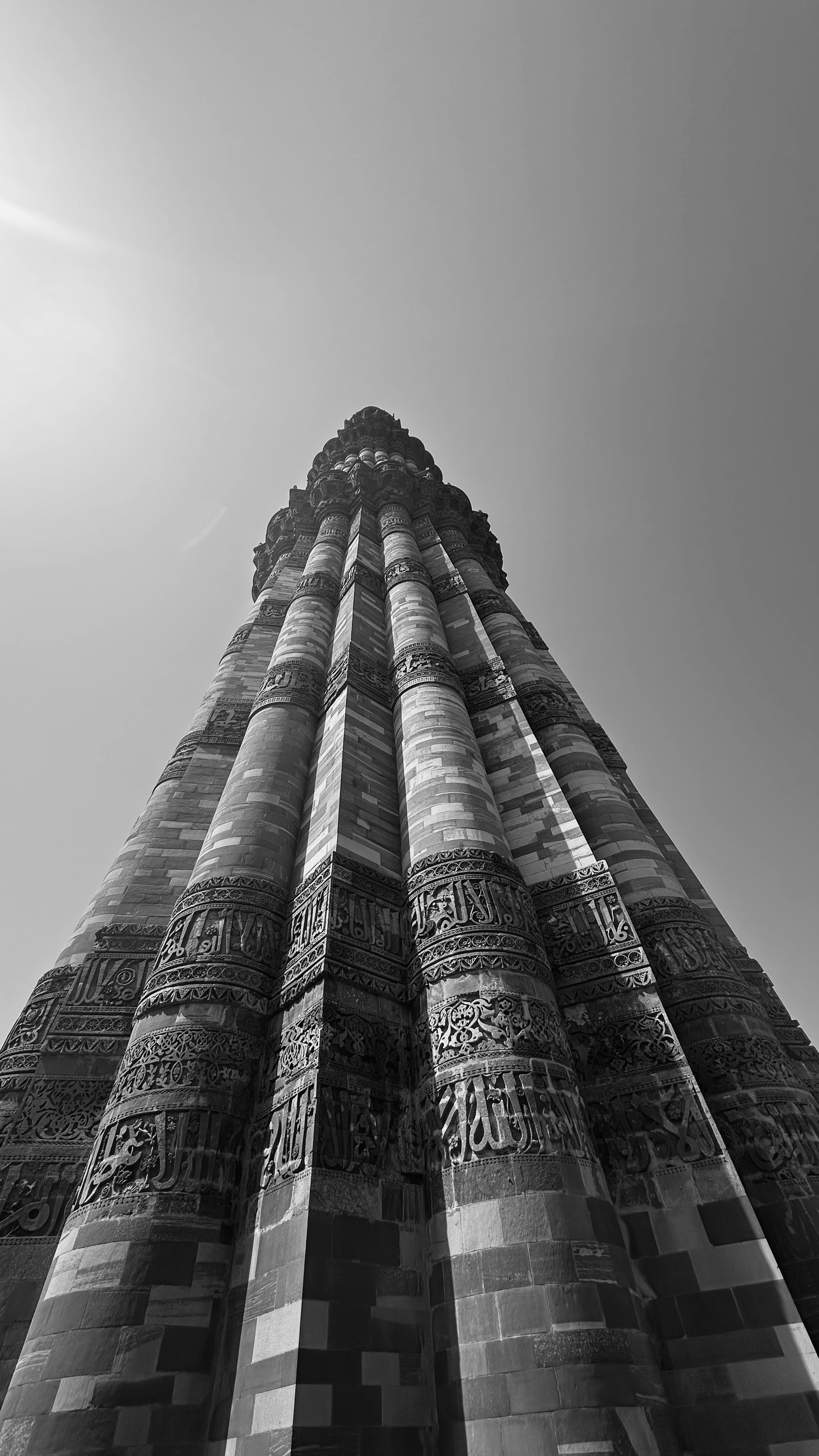 Vertical Echoes: A Low-Angle Portrait of a Carved Stone Tower