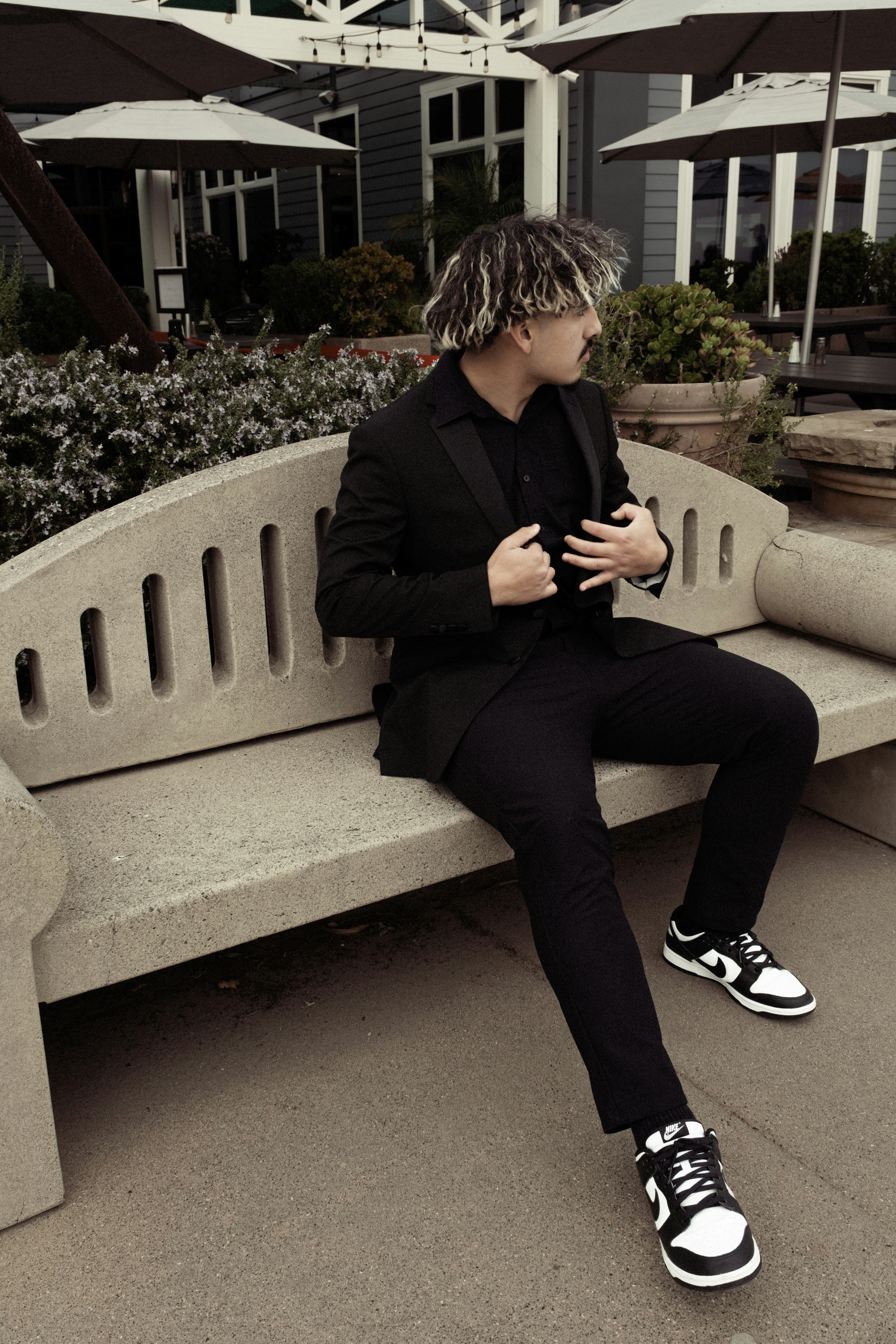 A man sitting on a cement bench in a black suit photo – Free Black ...