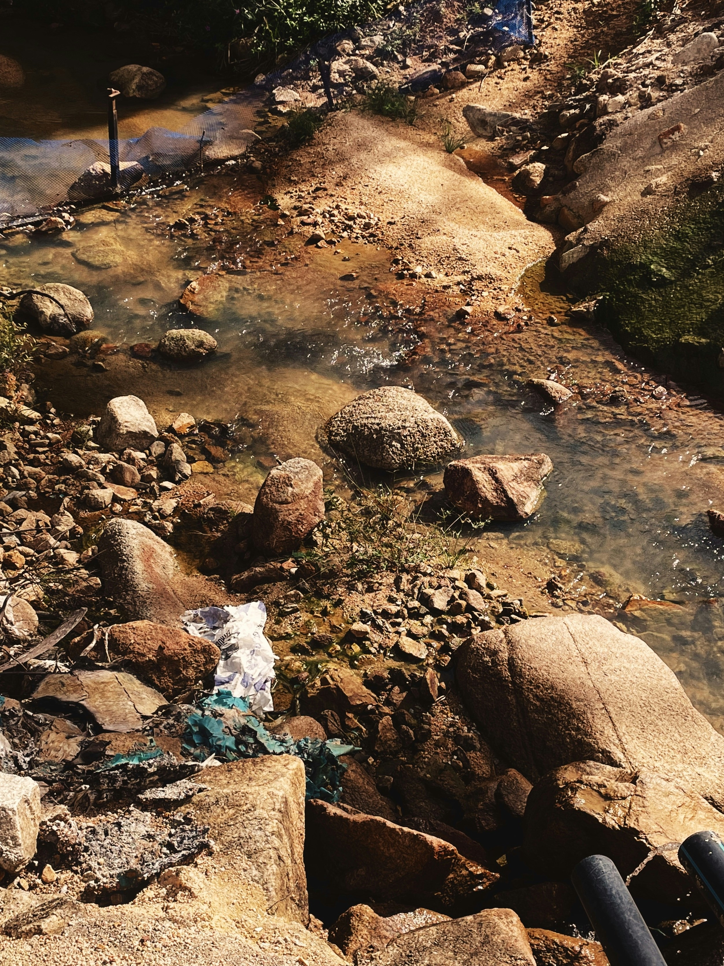 Sunlit Creek Among Round Boulders: A Rocky Riverside Moment