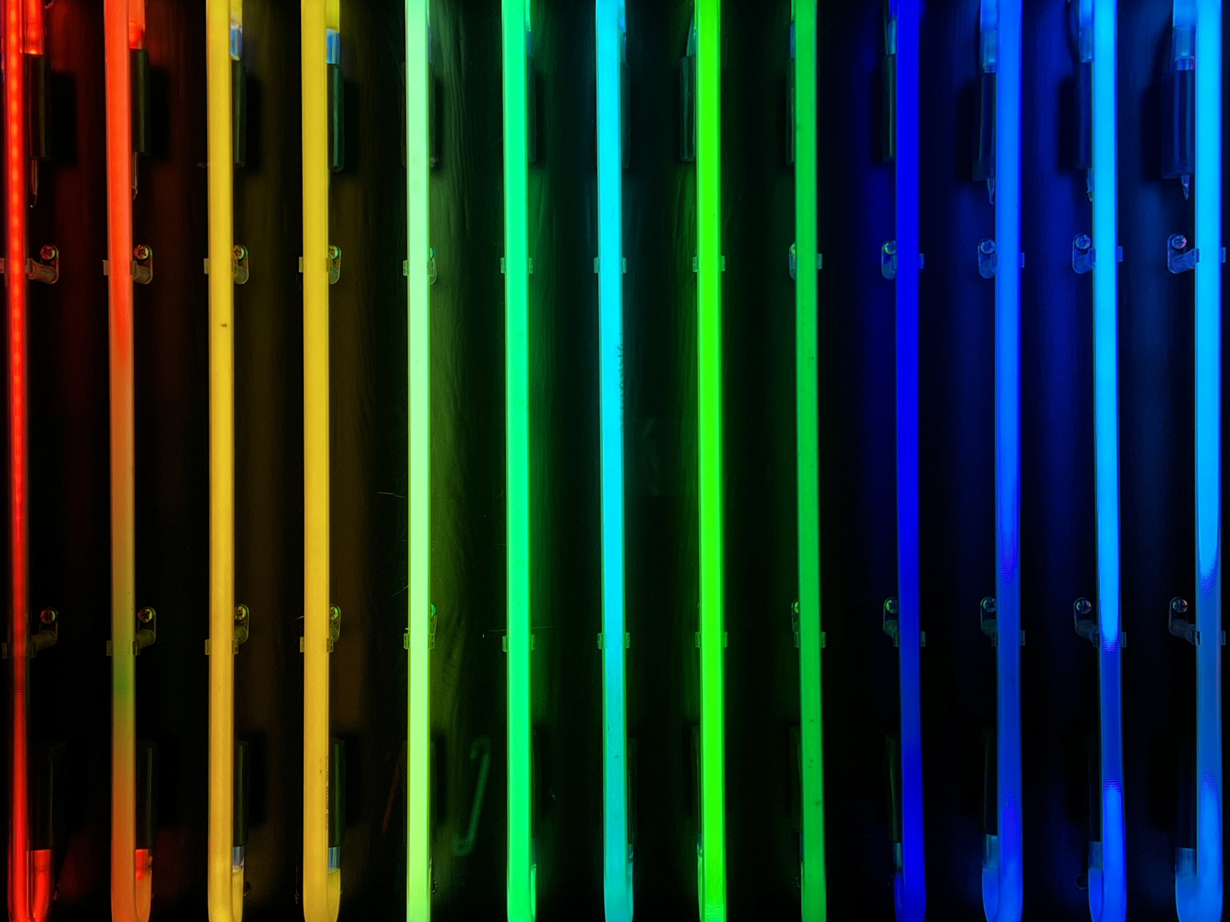 A row of multicolored radiators in front of a black background photo ...