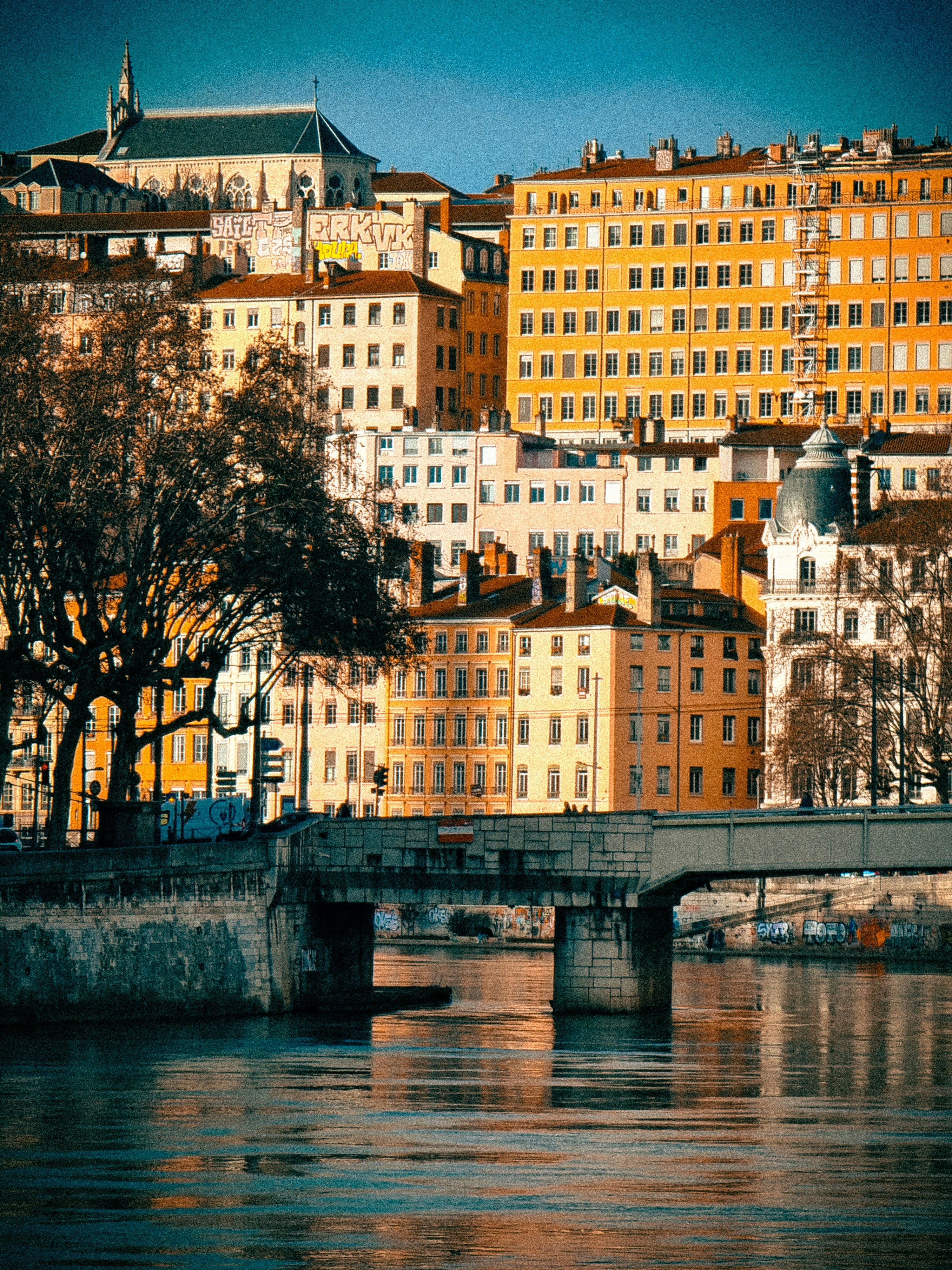 A bridge over a river with lots of buildings in the background photo ...