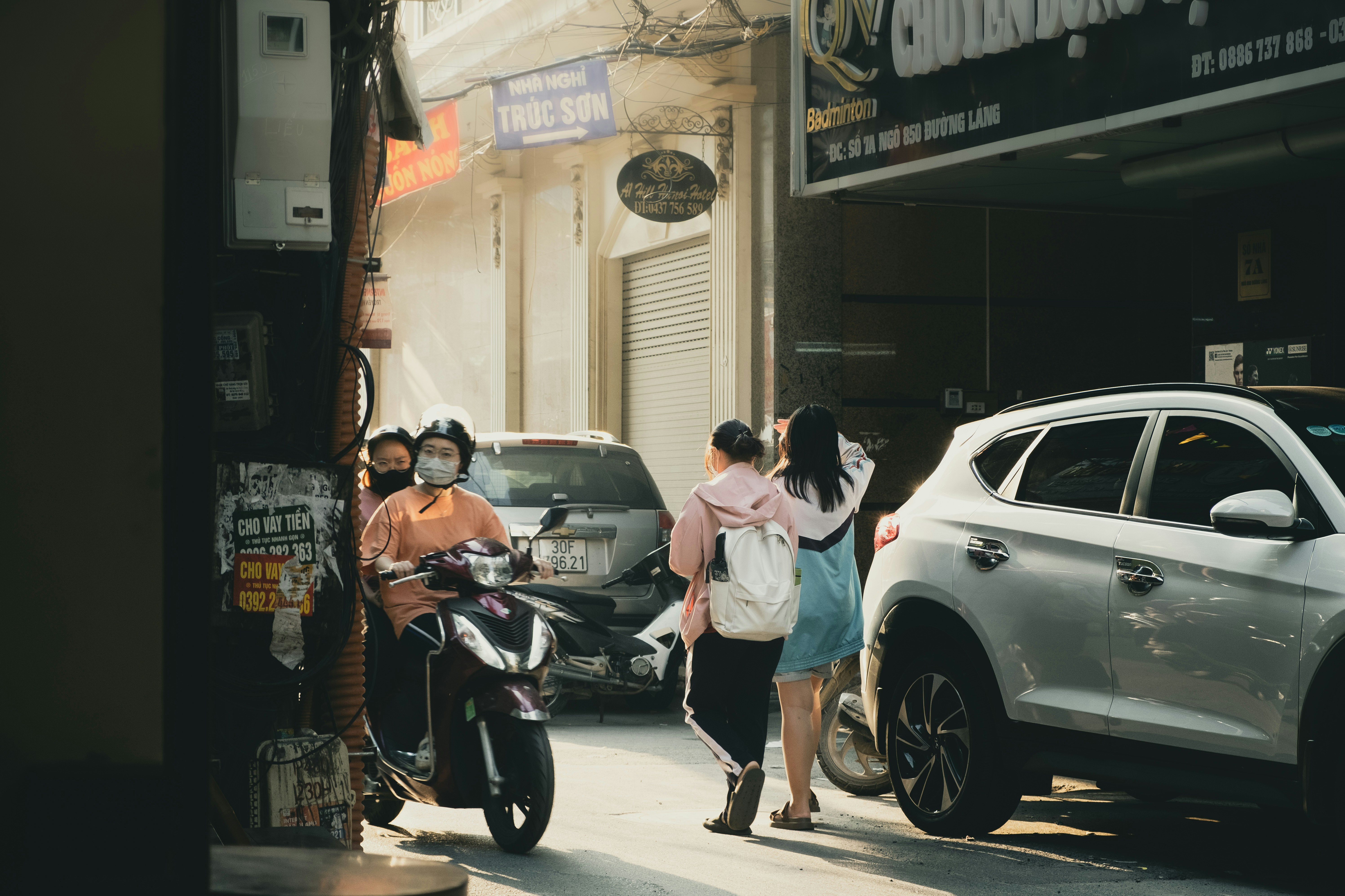 Sunlit Street Junction: Masks, Motors, and a Quiet City Moment