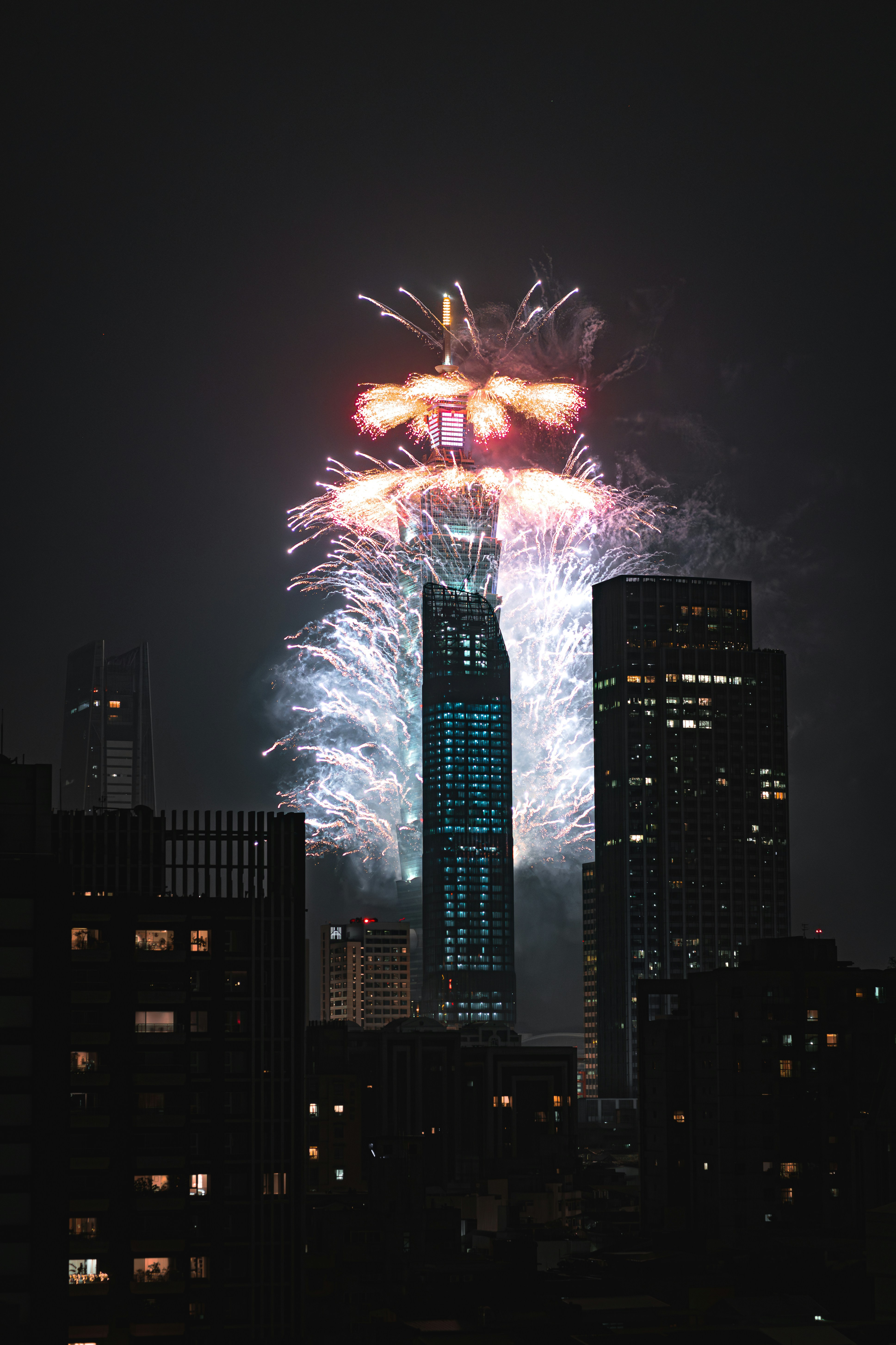 A very tall building with a lot of fireworks in the sky photo – Free ...