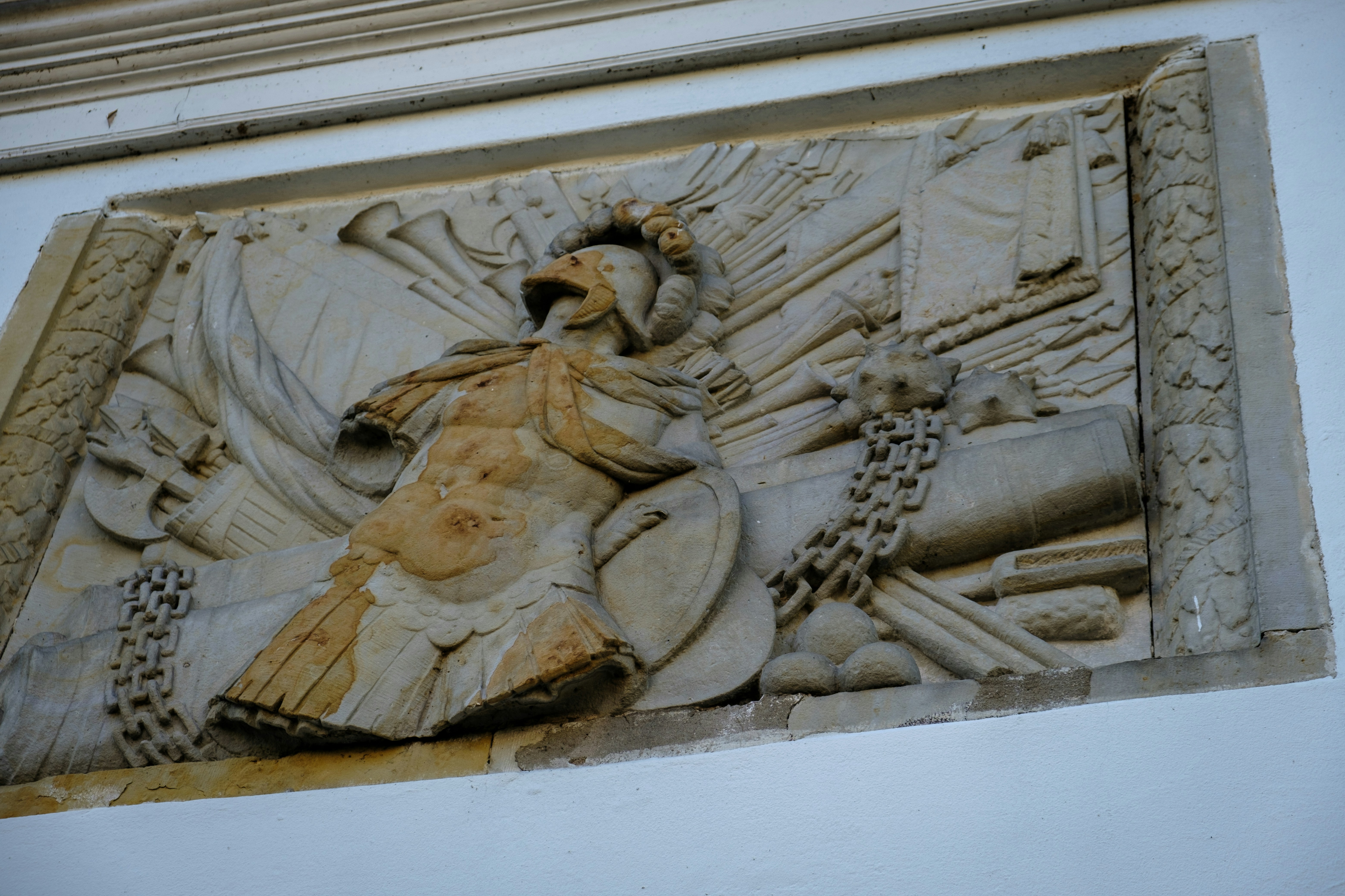 Bas-Relief of a Helmeted Warrior: Stone Frieze in Mid-Pose Drama