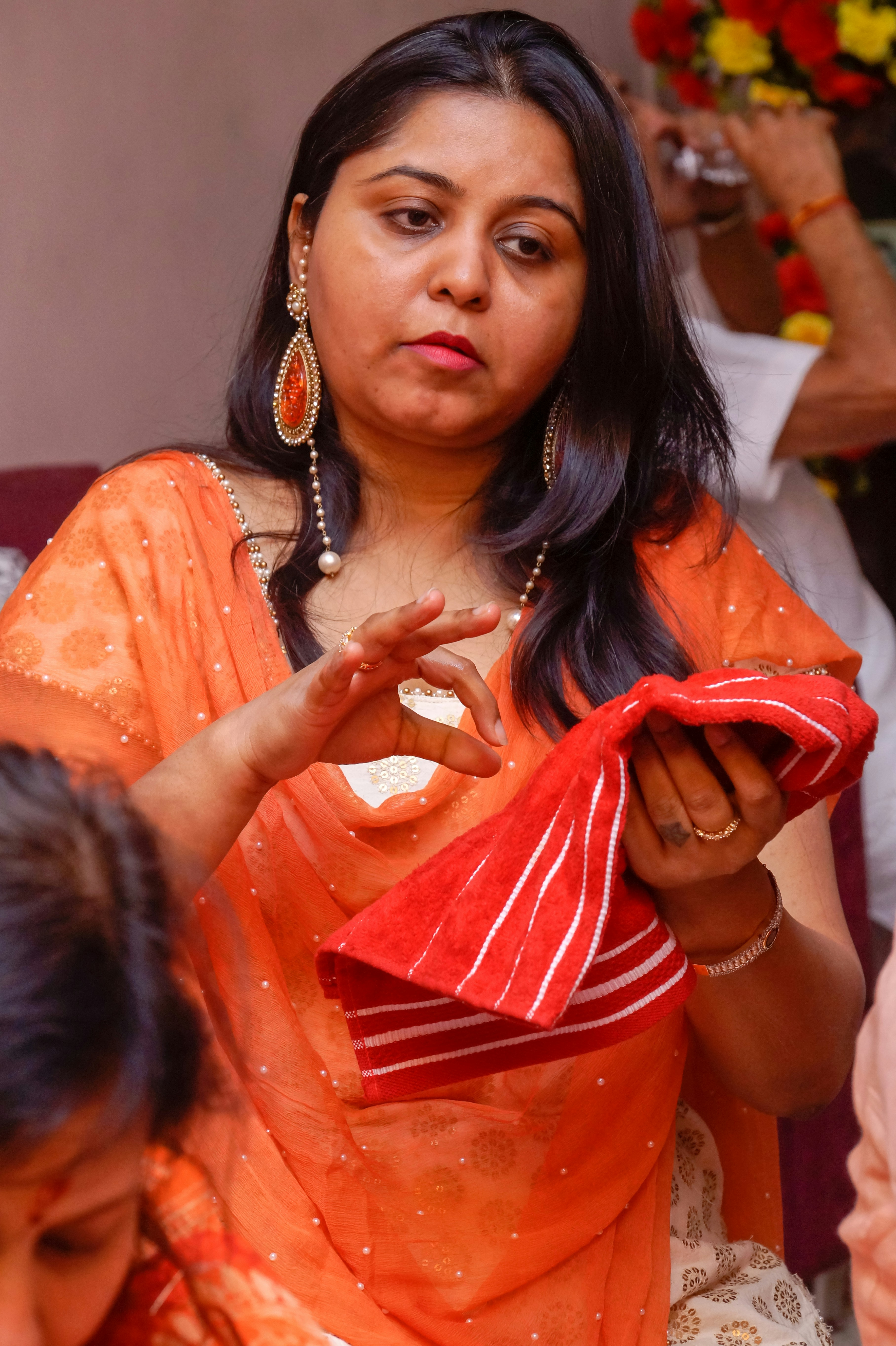 A woman in an orange sari holding a red cloth photo – Free Woman Image ...