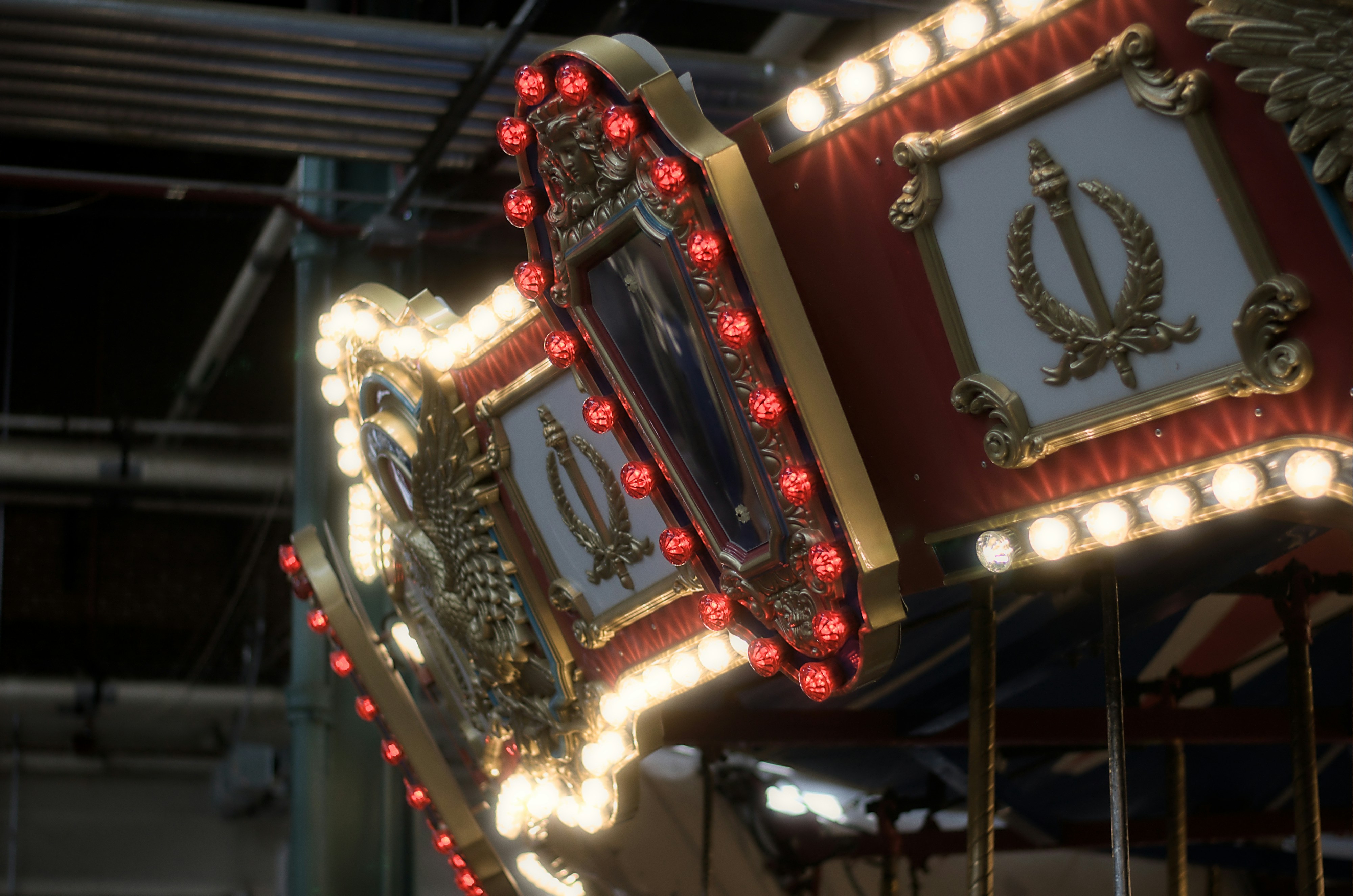 Golden Crest Under Warm Bulbs: A Close-Up of a Vintage Carousel Emblem