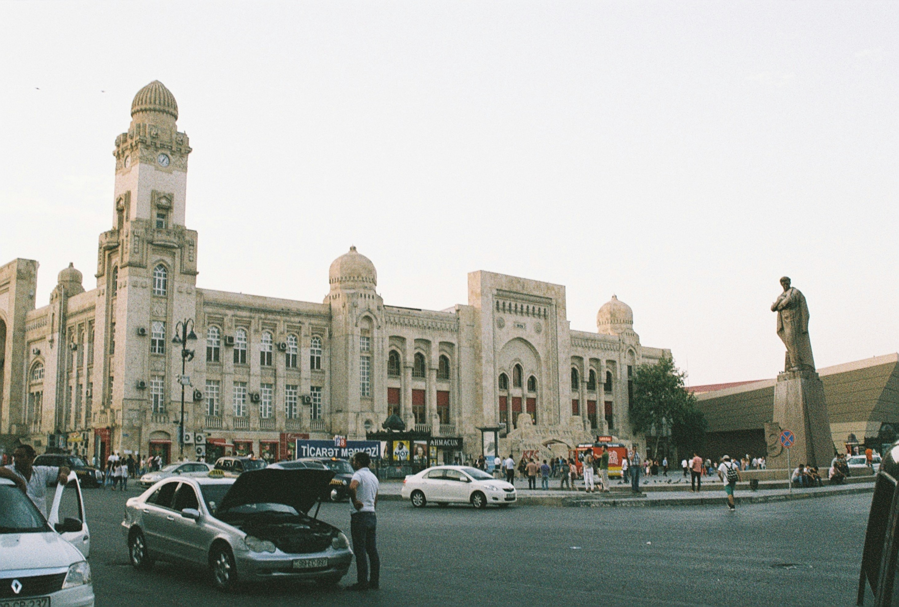 Ornate Facade, Busy Plaza, and a Monumental Sentinel