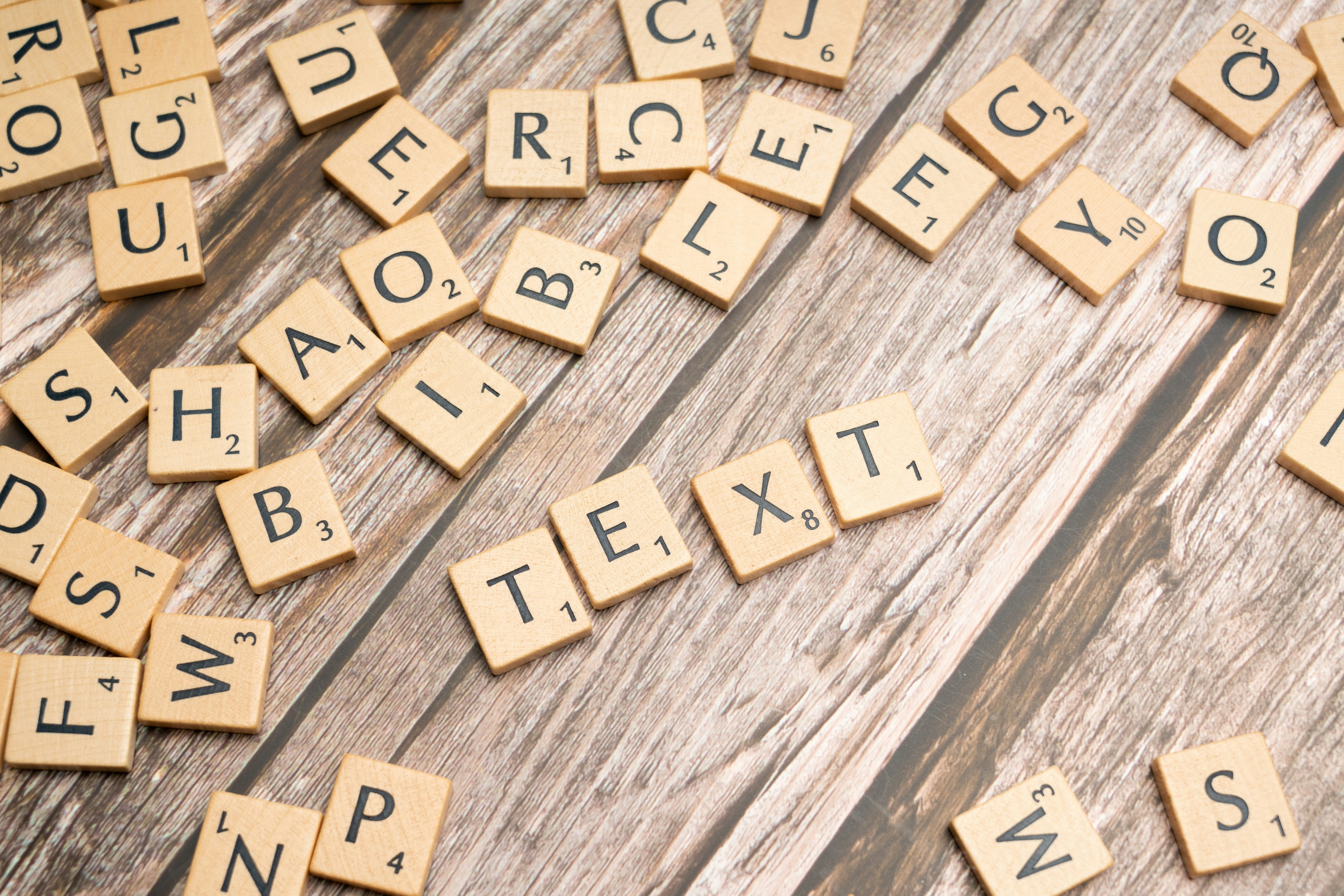A close up of scrabble letters on a wooden surface photo – Free Text ...