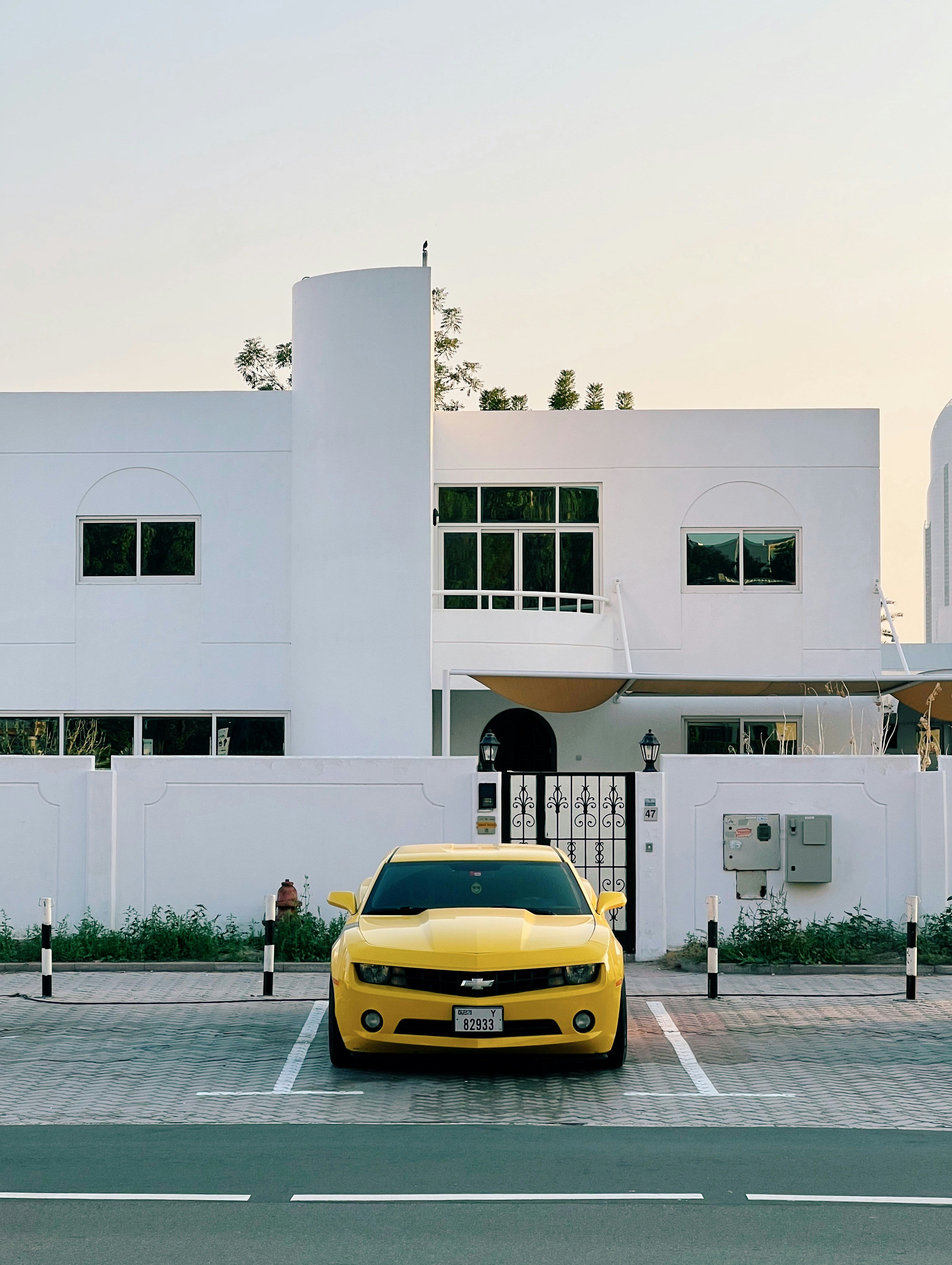 Sunlit Yellow Camaro Anchors a Minimalist White Facade