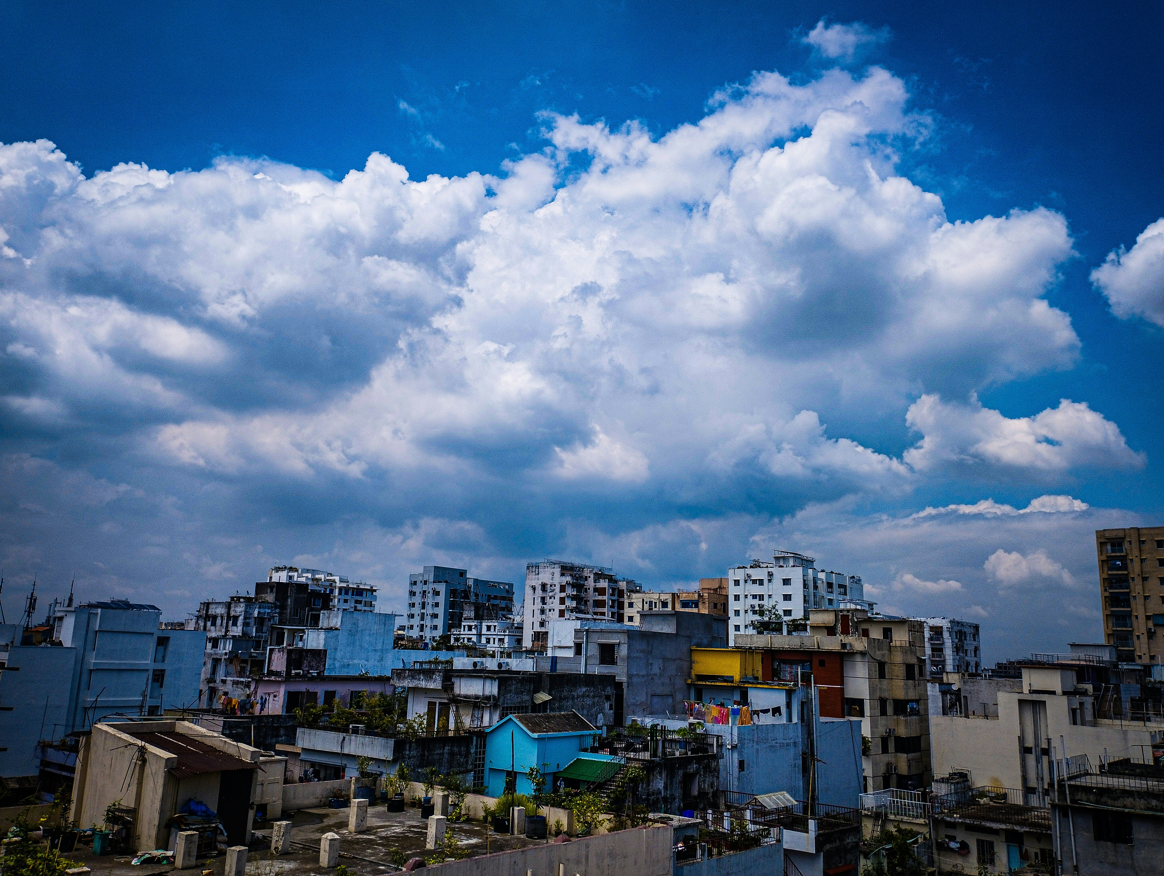 A cloudy sky over a city with lots of buildings photo – Free Blue Image ...