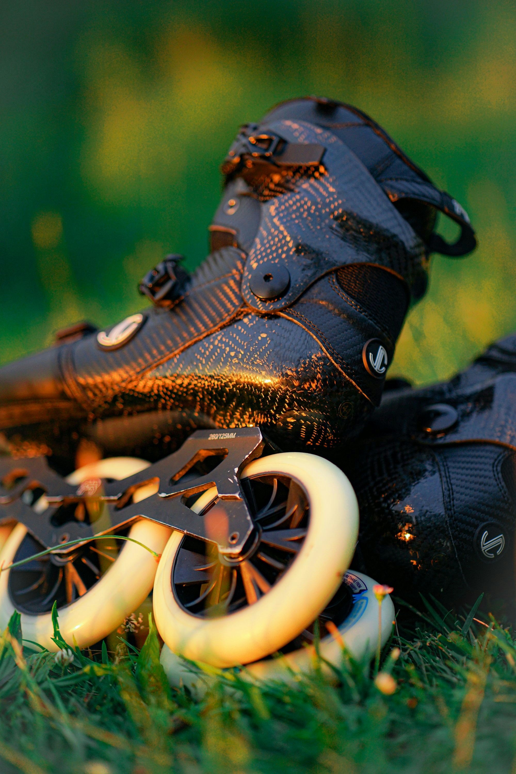 Golden Hour on Wheels: A Close-Up of Black Inline Skates Resting in Grass