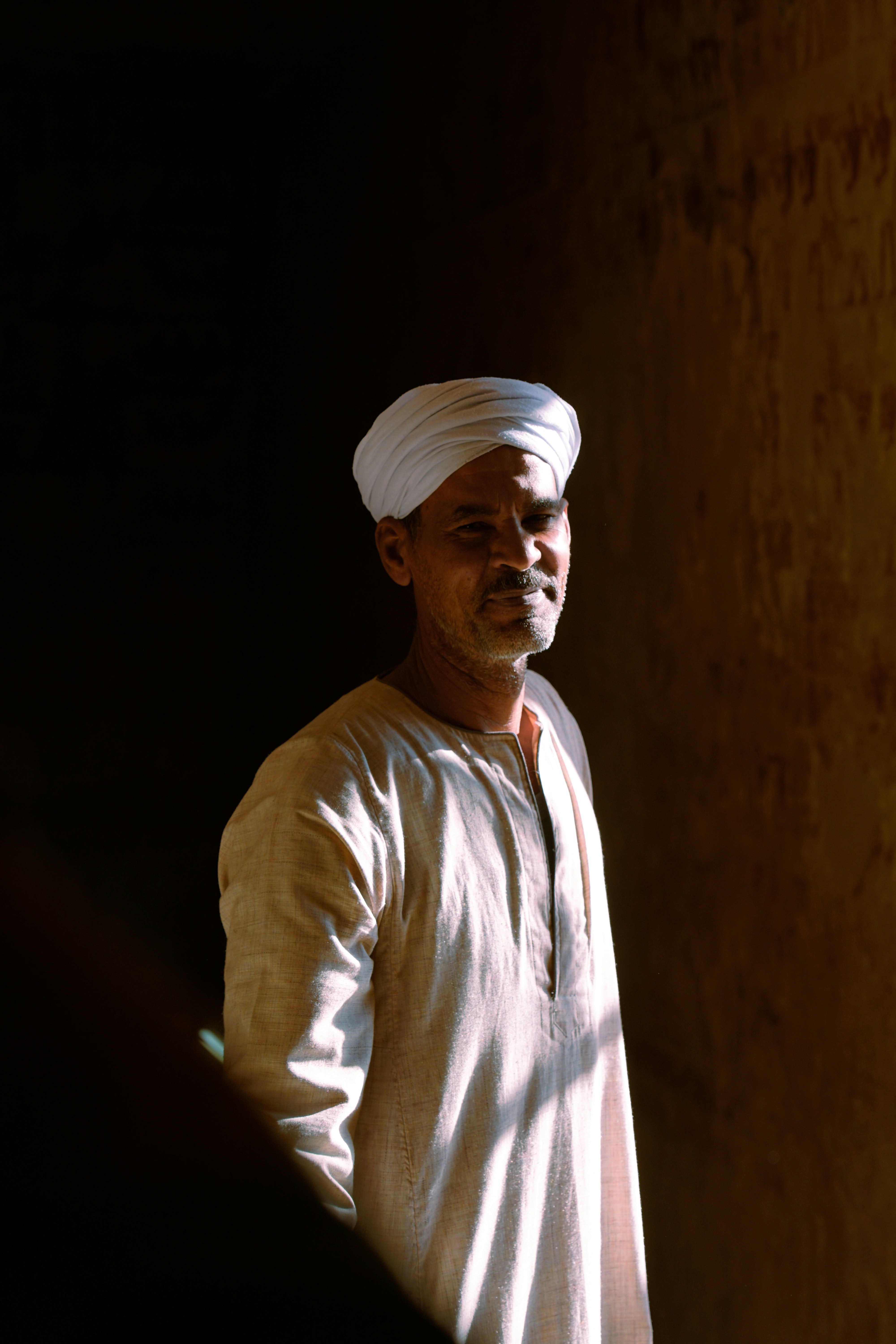 Warm Spotlight in a Dim Corridor: Portrait of a Turbaned Figure
