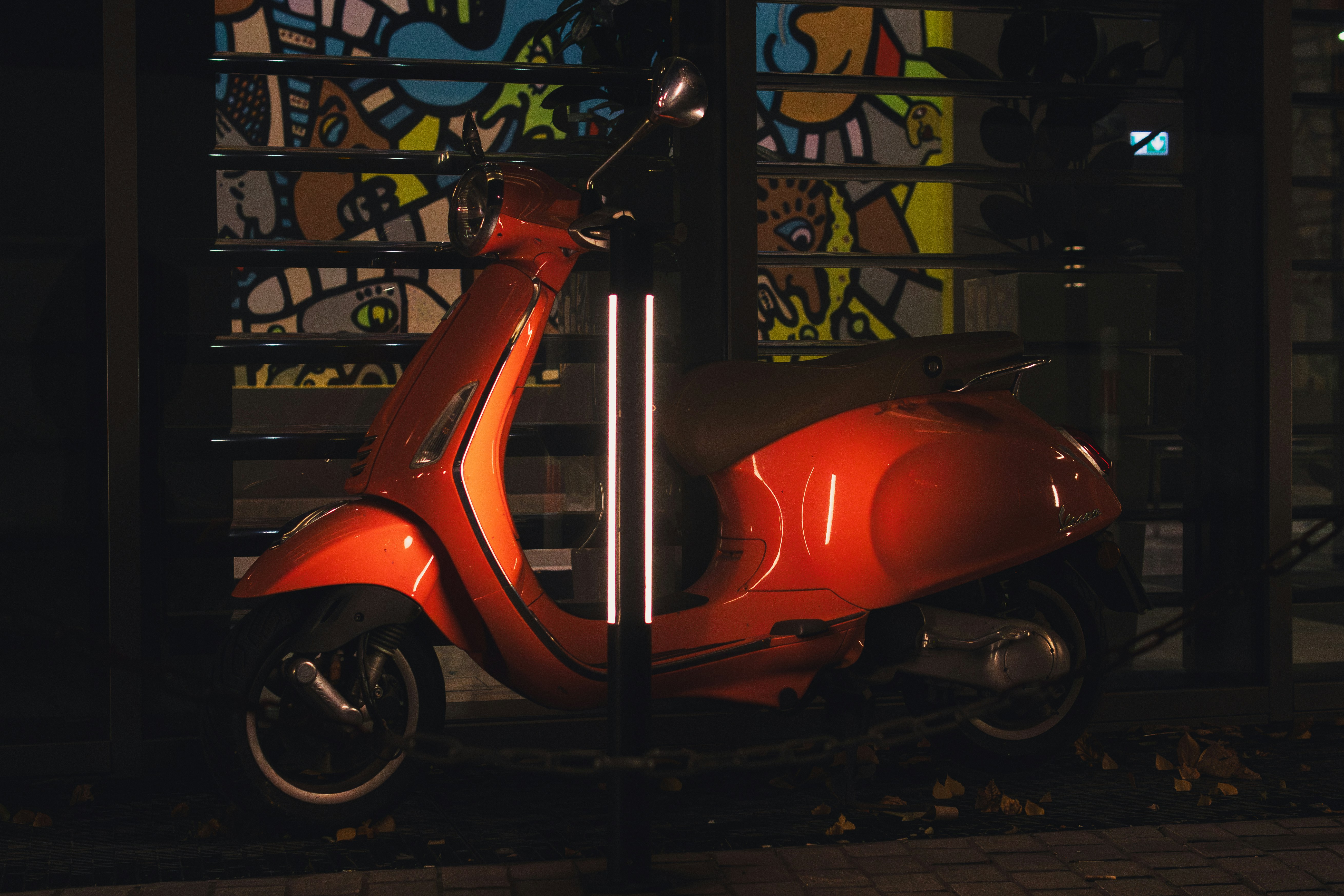 Crimson Vespa Under Neon Graffiti: Night Portrait by a Quiet Street