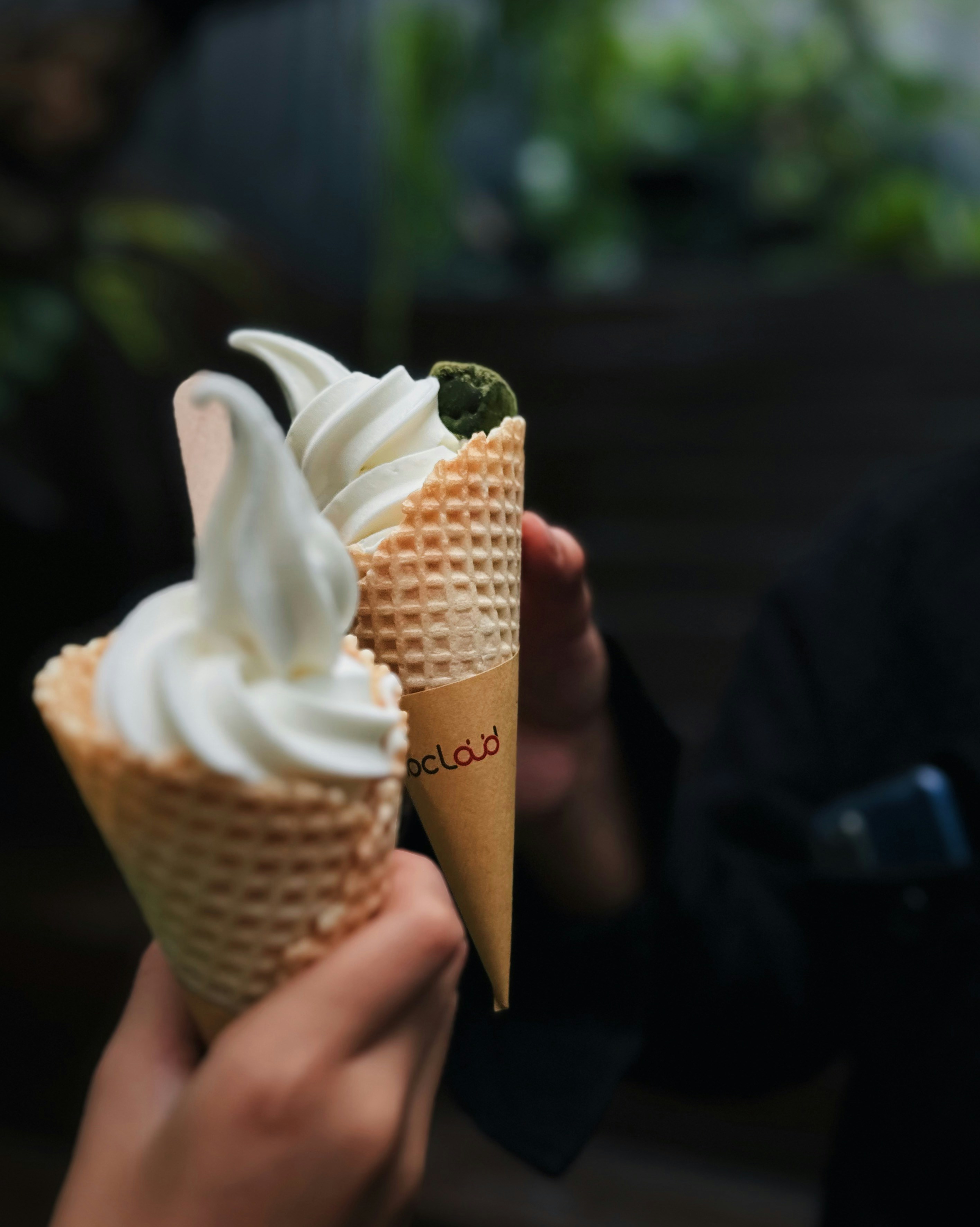 Two Vanilla Soft-Serve Cones shared in a soft-focus courtyard