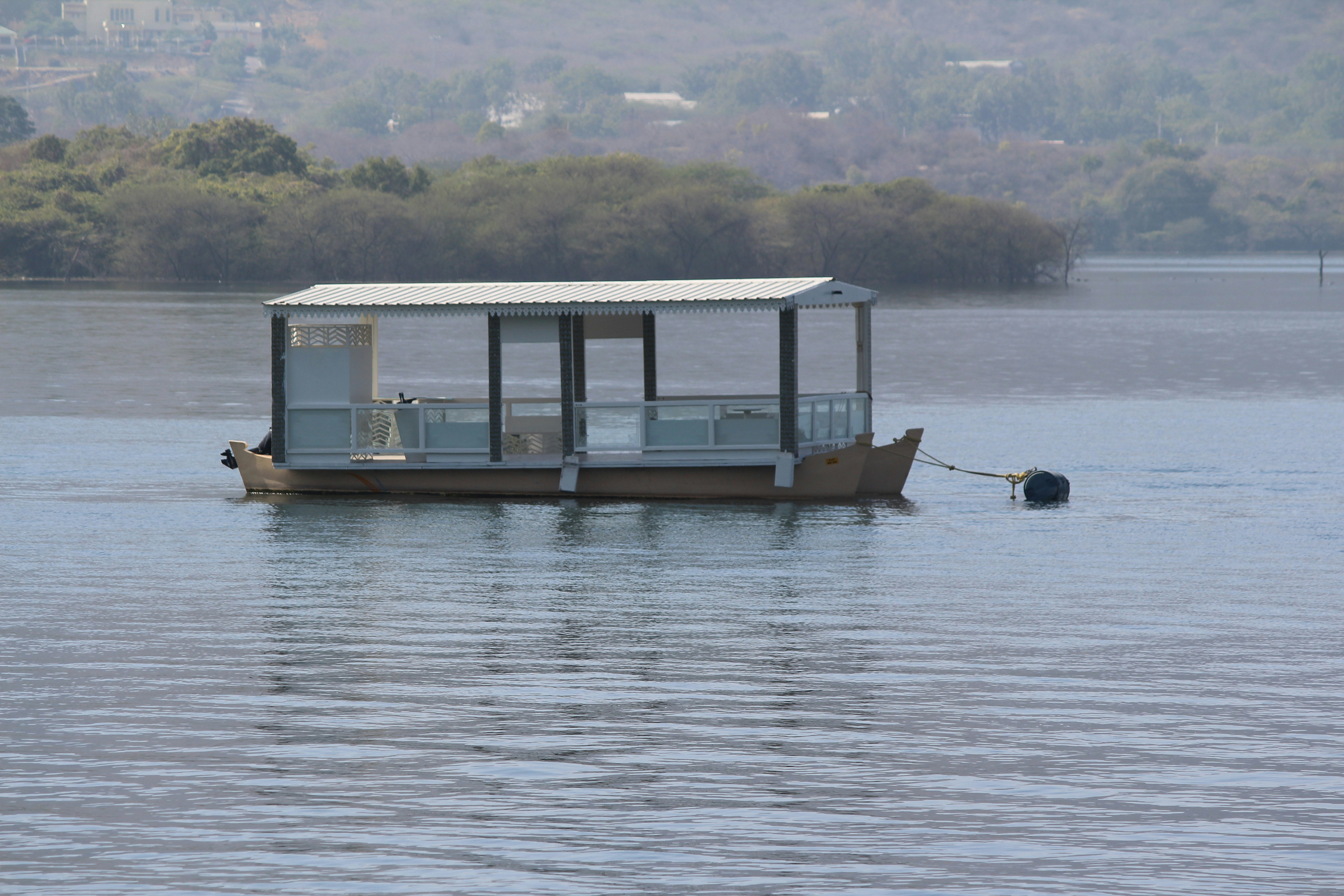 A small boat floating on top of a lake photo – Free Udaipur Image on ...