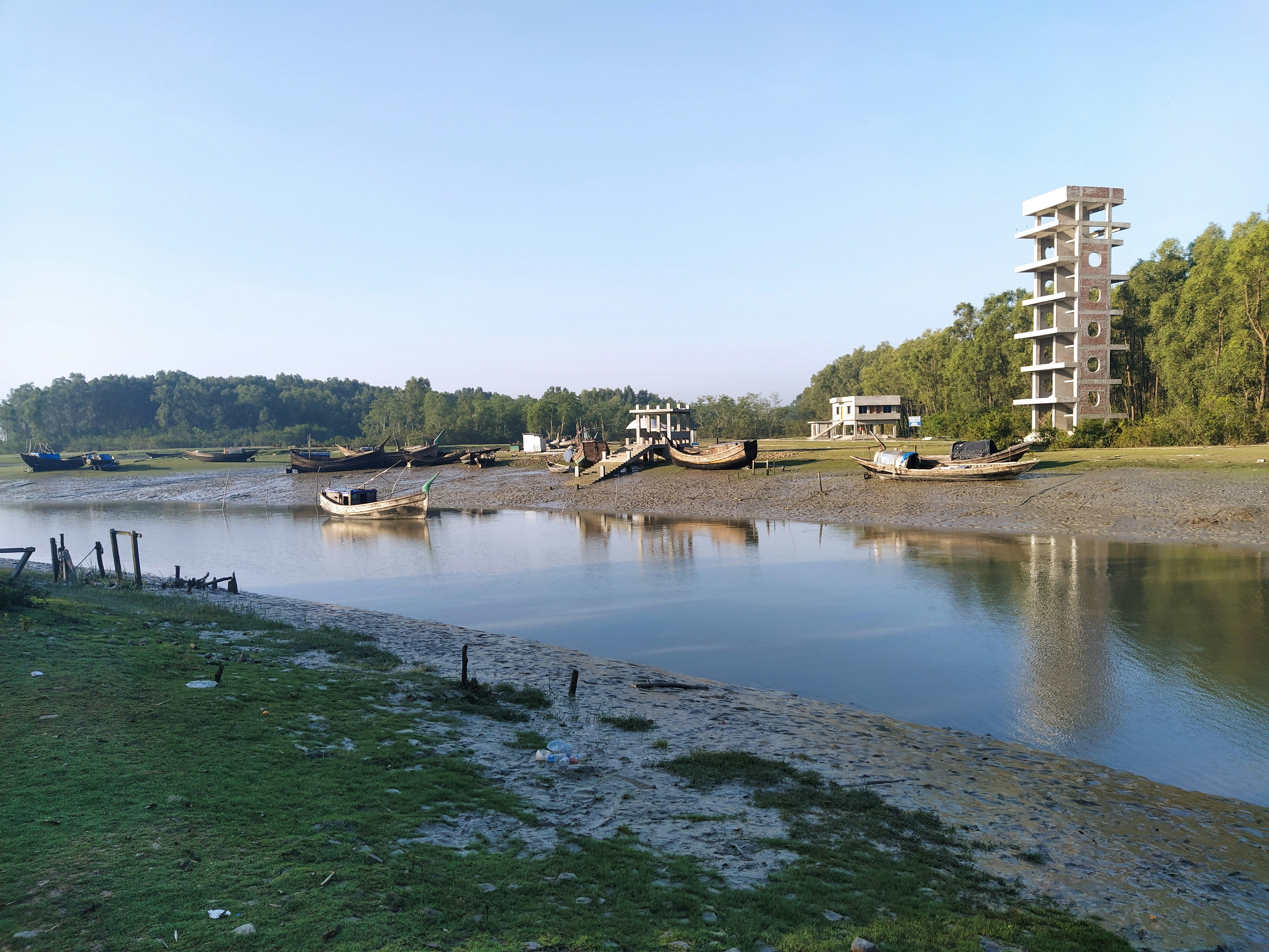 Boats at Low Tide Framed by a Riverside Tower