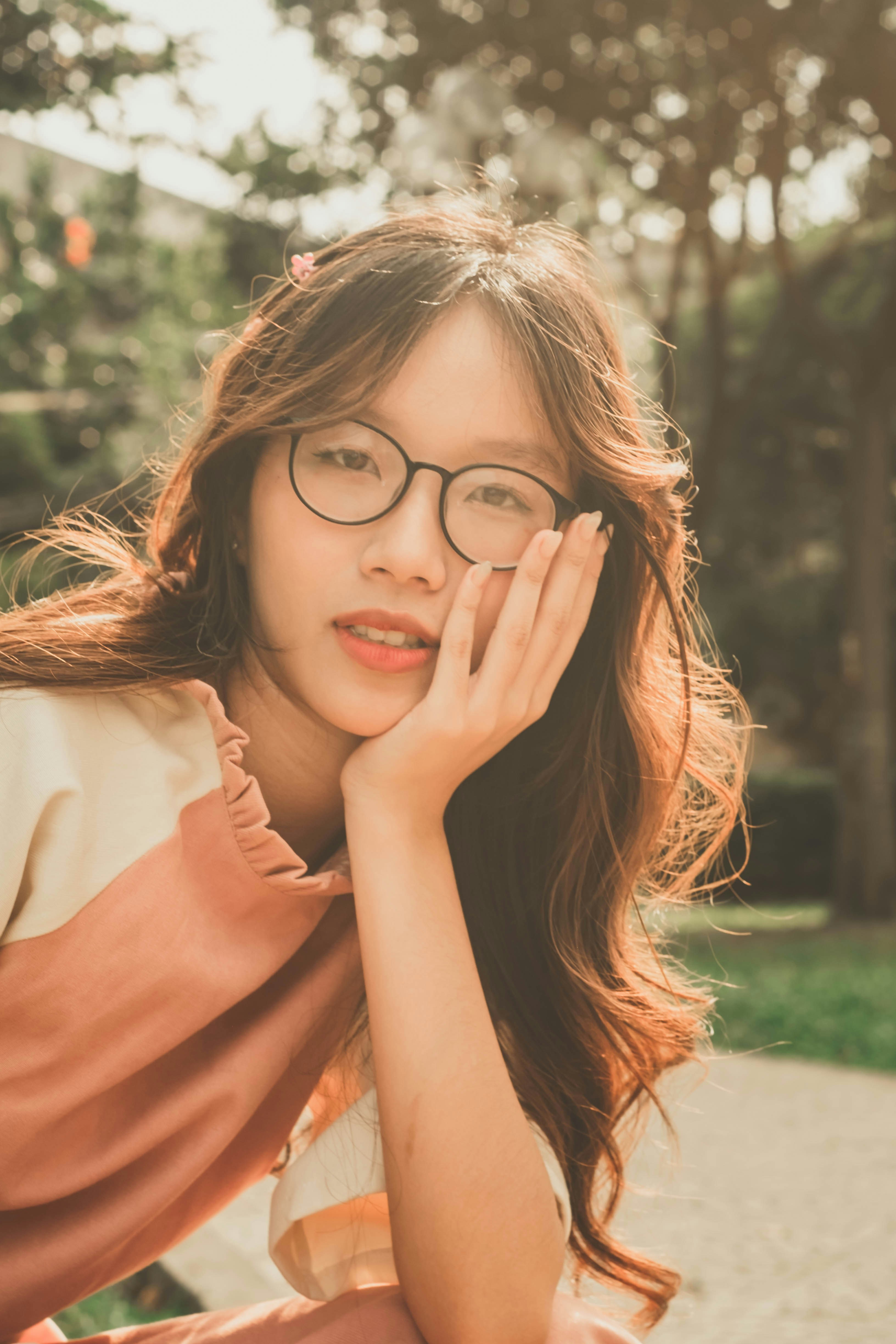 Una mujer con gafas sentada en un banco foto – Imagen de Retrato gratuita en Unsplash