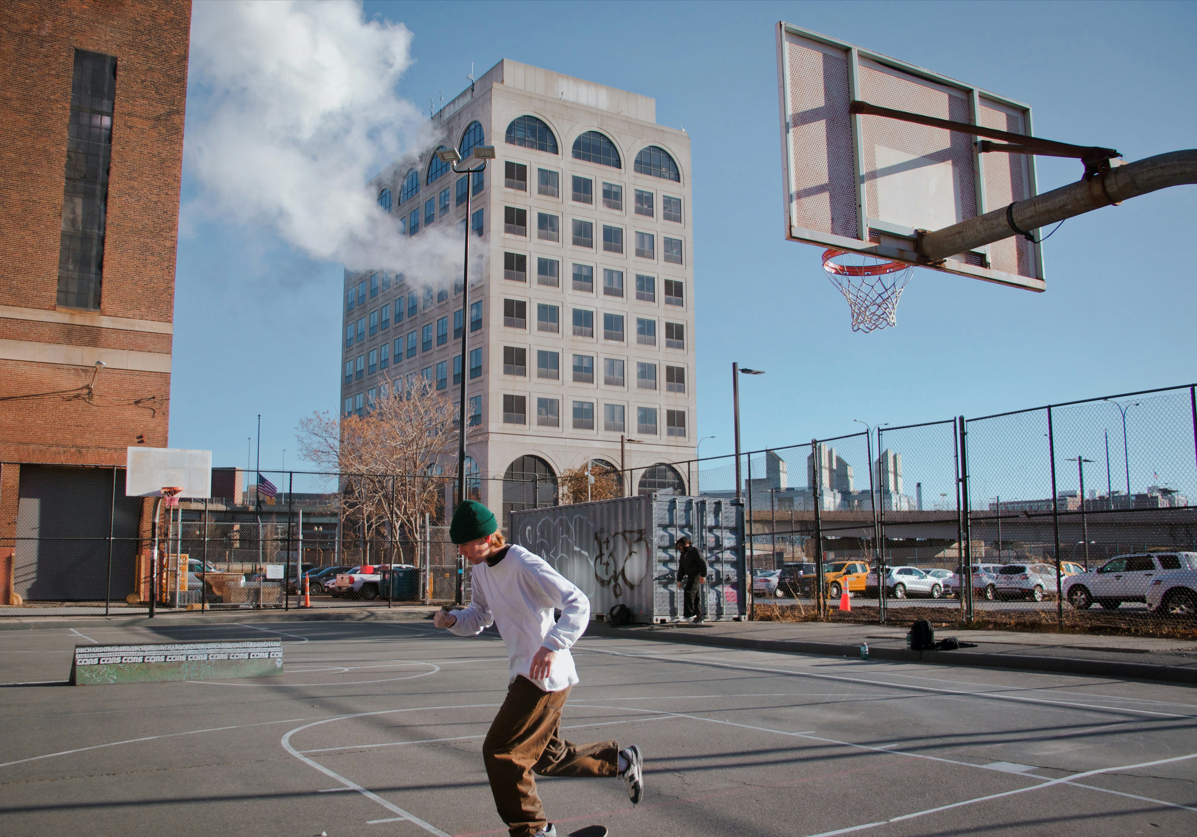 A man riding a skateboard on top of a basketball court photo – Free ...