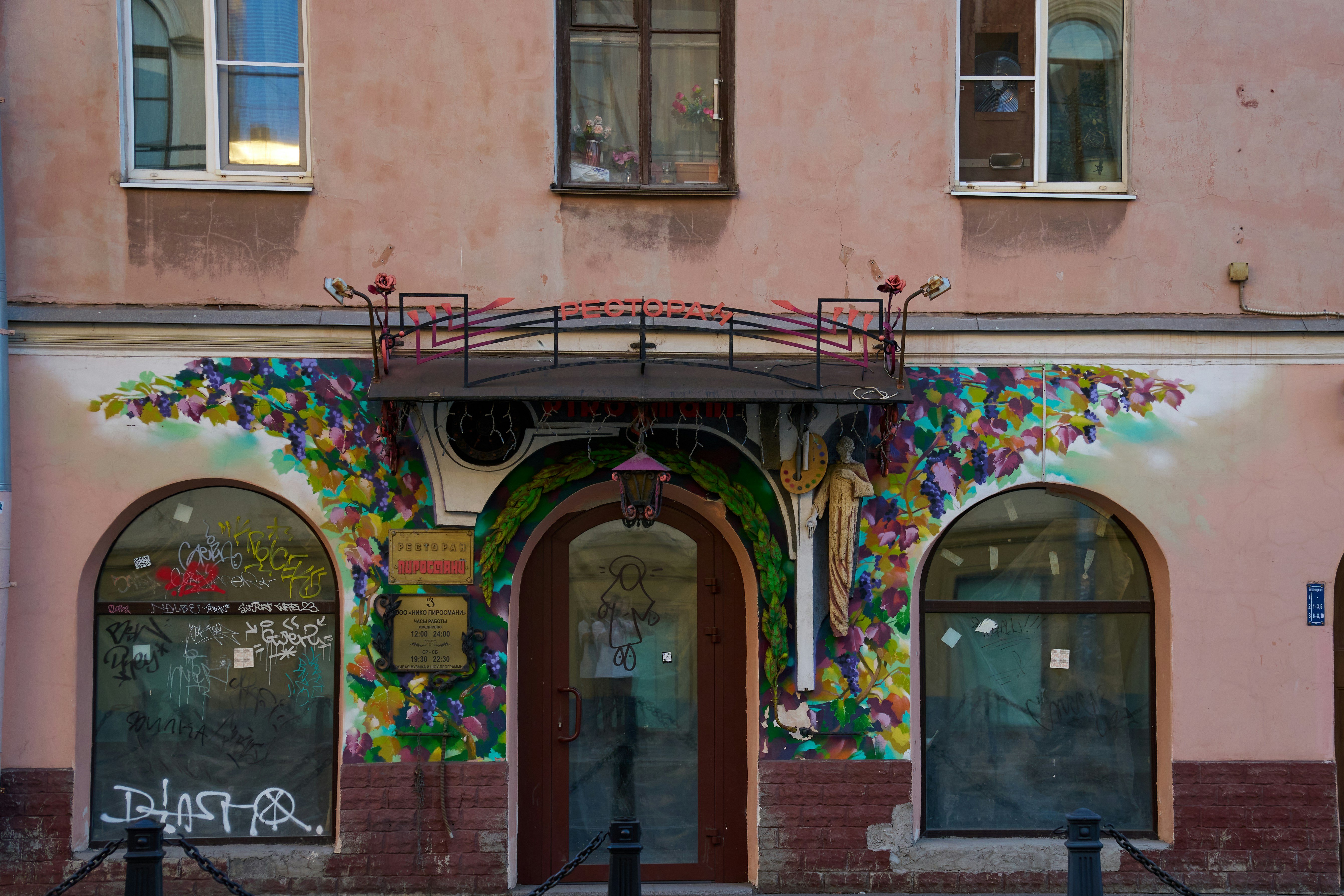 Floral Arch: A Pink Facade Framed by Vibrant Murals