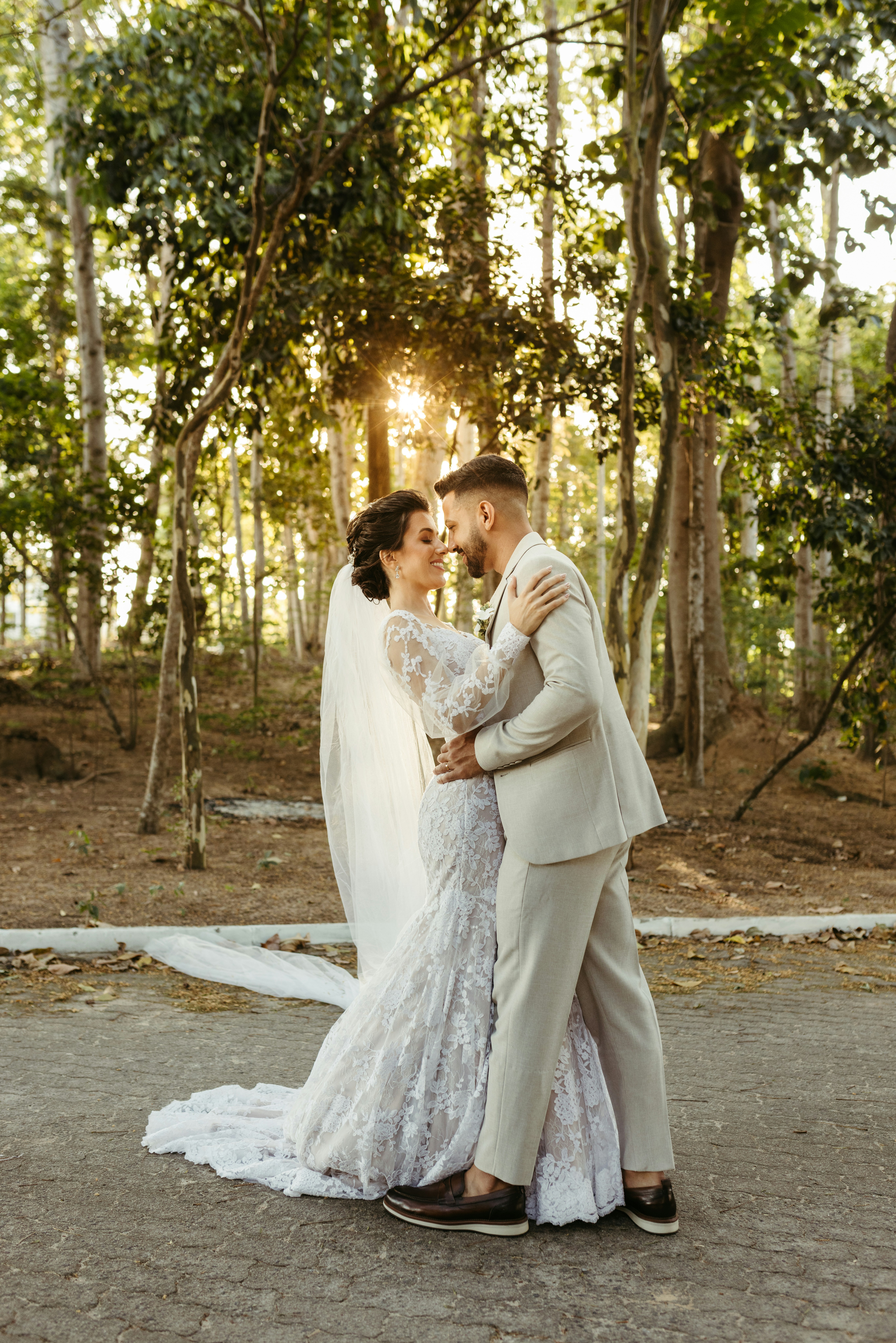 A bride and groom embracing in front of trees photo – Free Face Image ...
