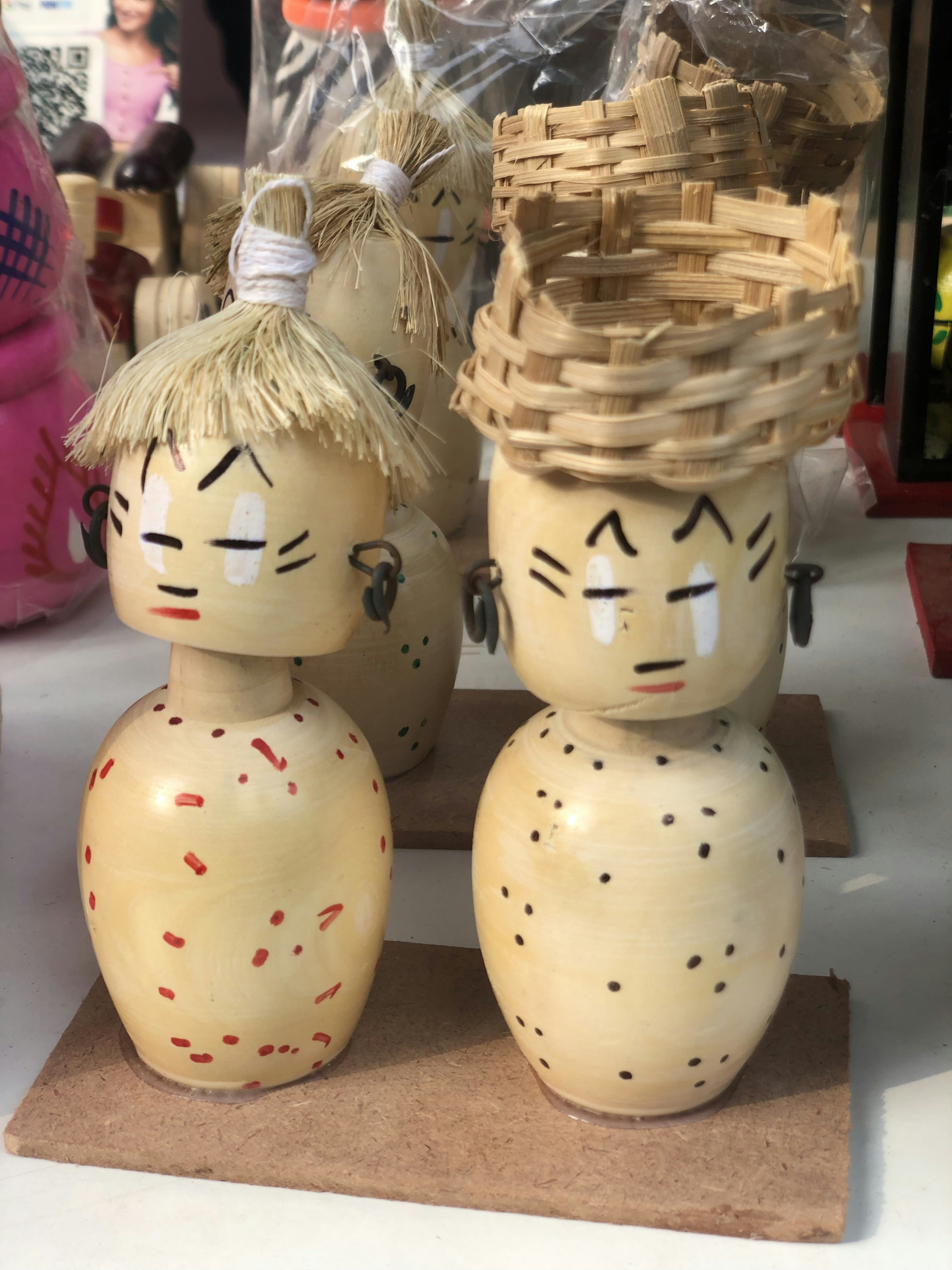 Straw-Hatted Wooden Duet on a Display Shelf