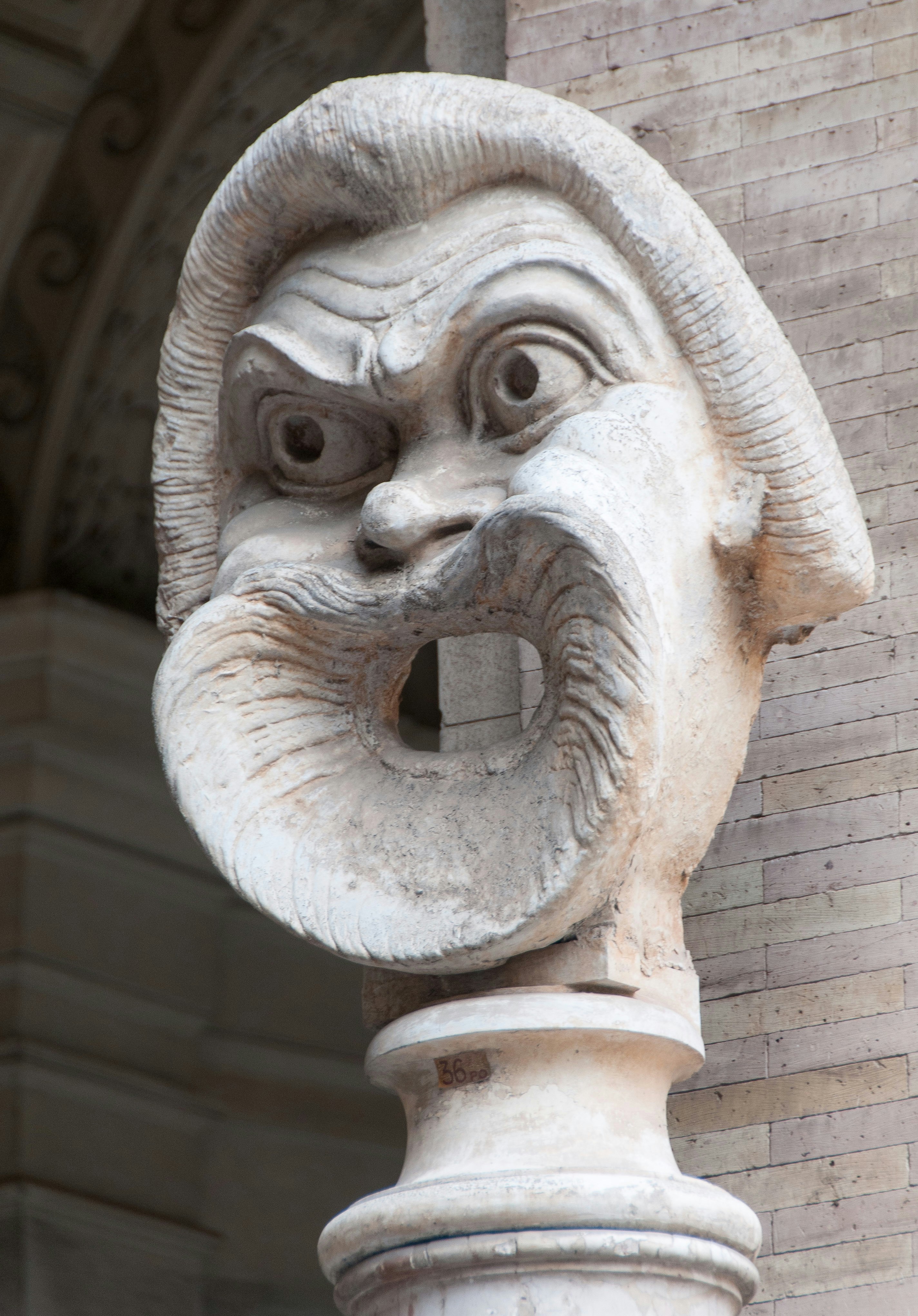 Open-Mouthed Stone Gargoyle: Weathered Portrait in Marble
