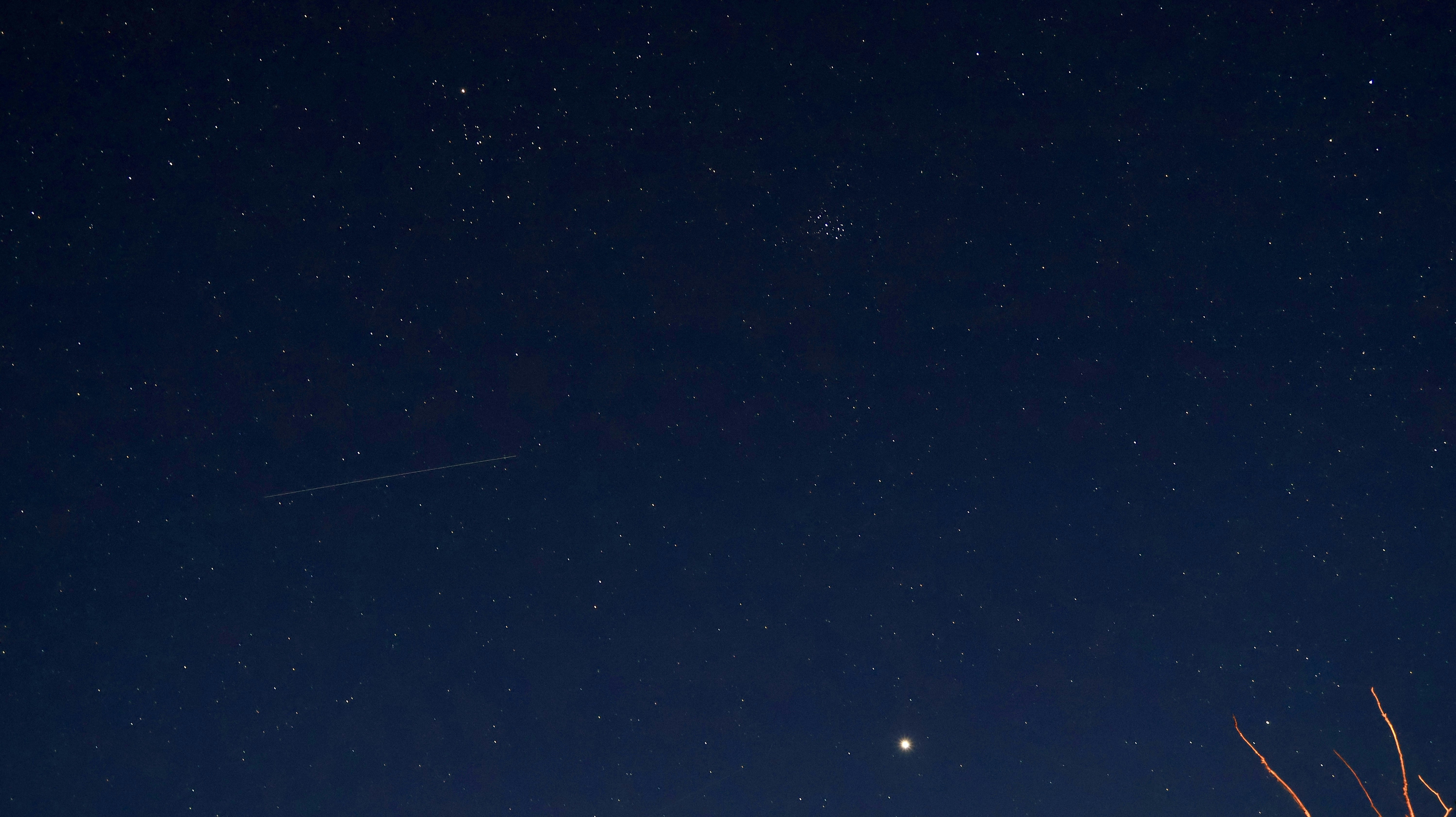 A night sky with a few stars and a small object in the distance photo ...