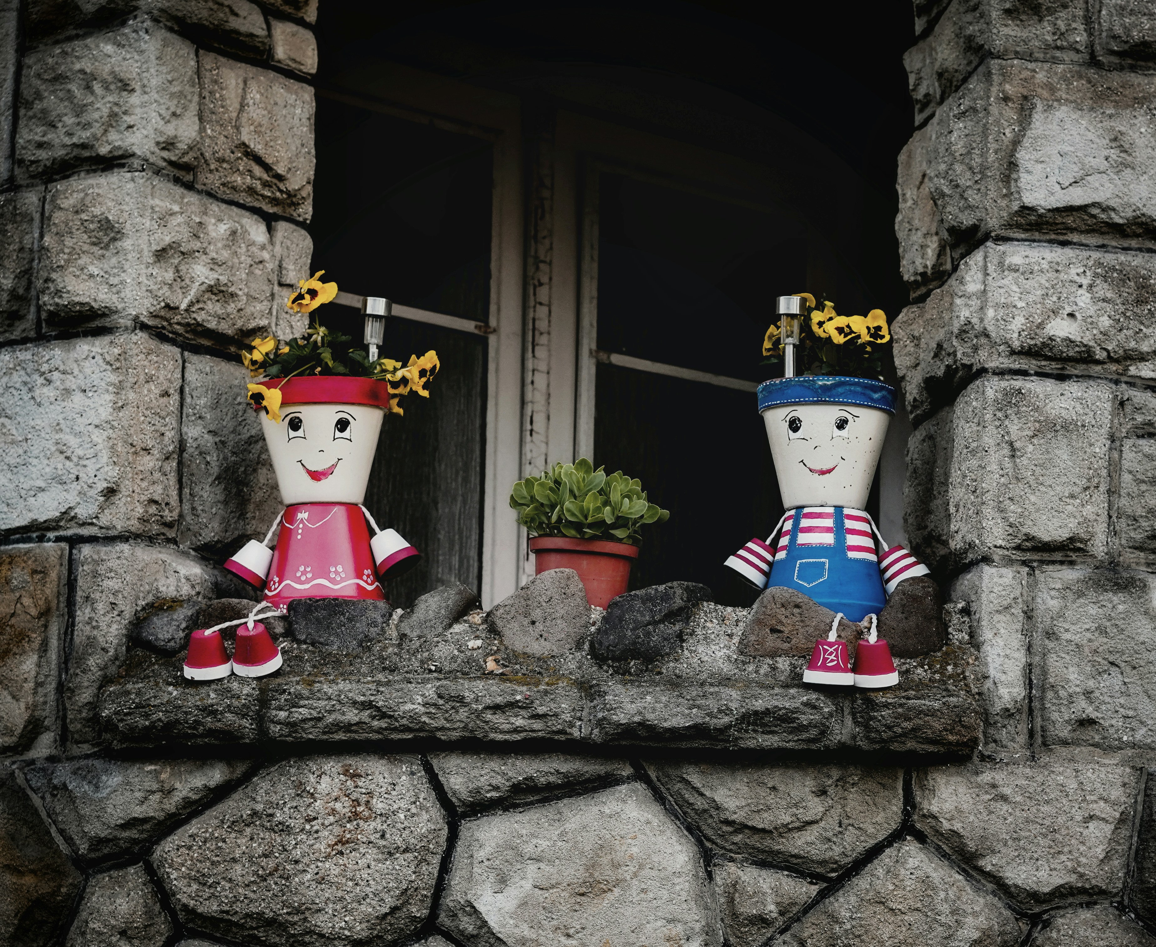 A couple of toy figures sitting on top of a window sill photo – Free ...