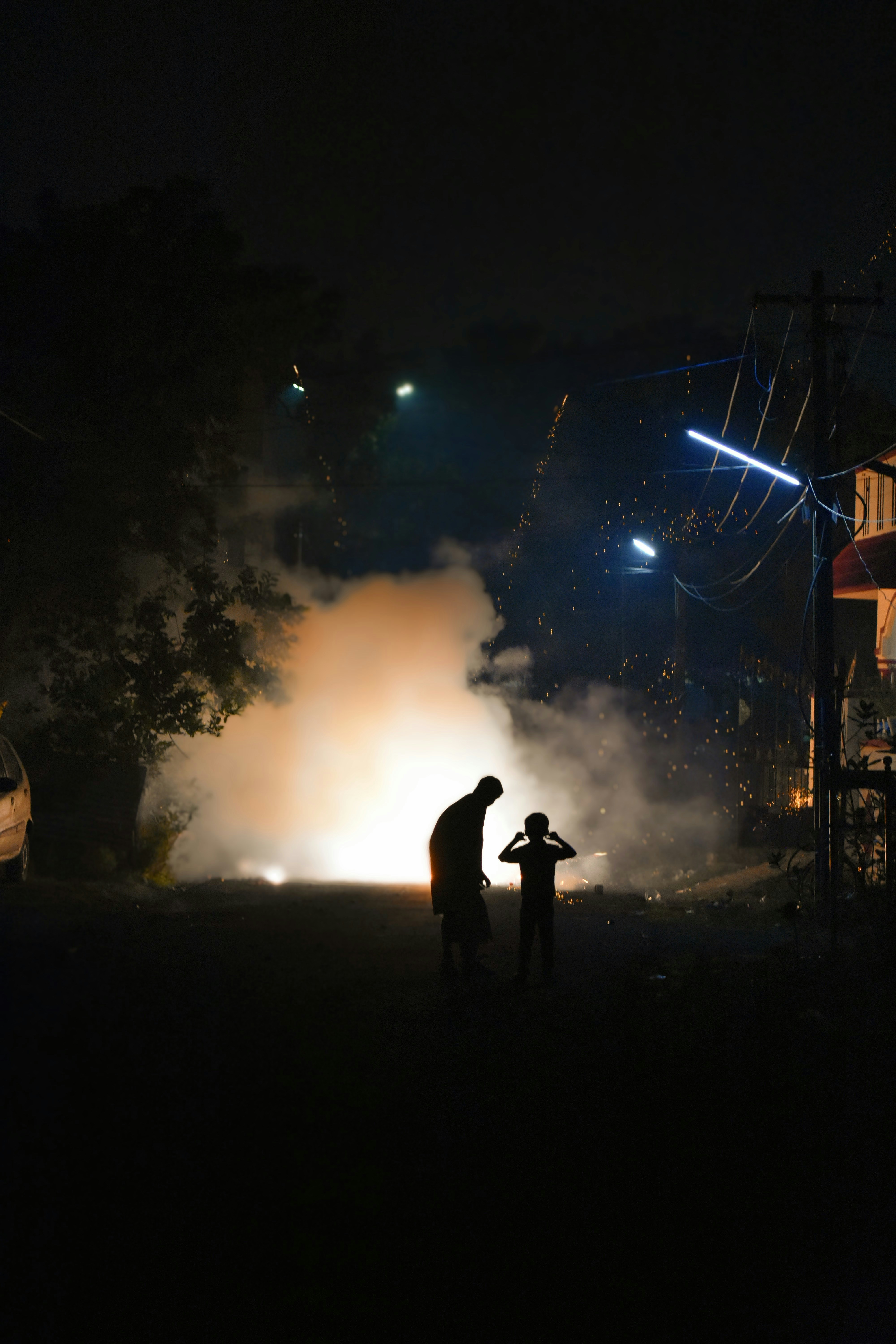 A couple of people standing next to a fire hydrant photo – Free Night ...