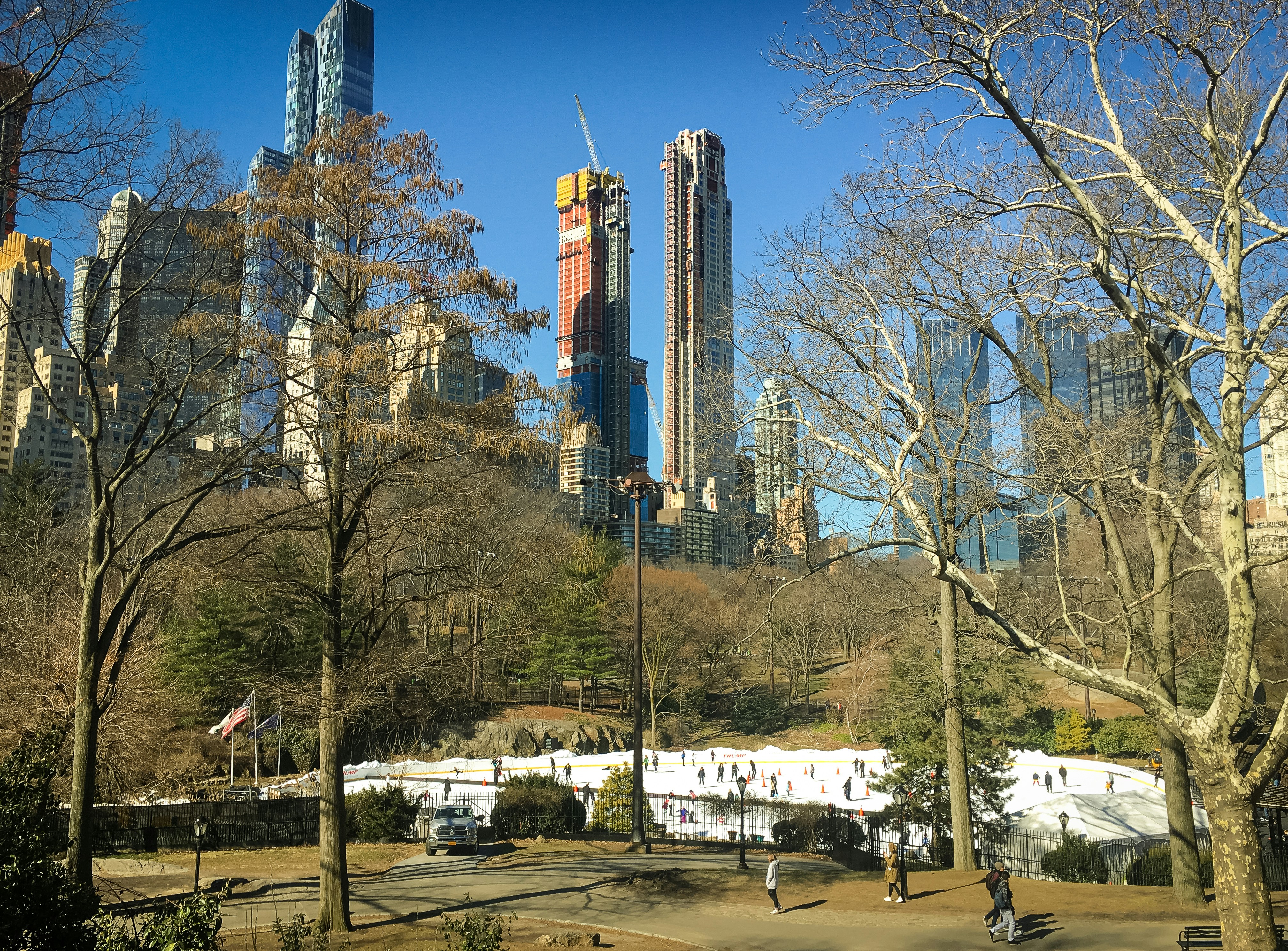 Crane-Topped Skyline Rising Over a Winter Park Ice Rink