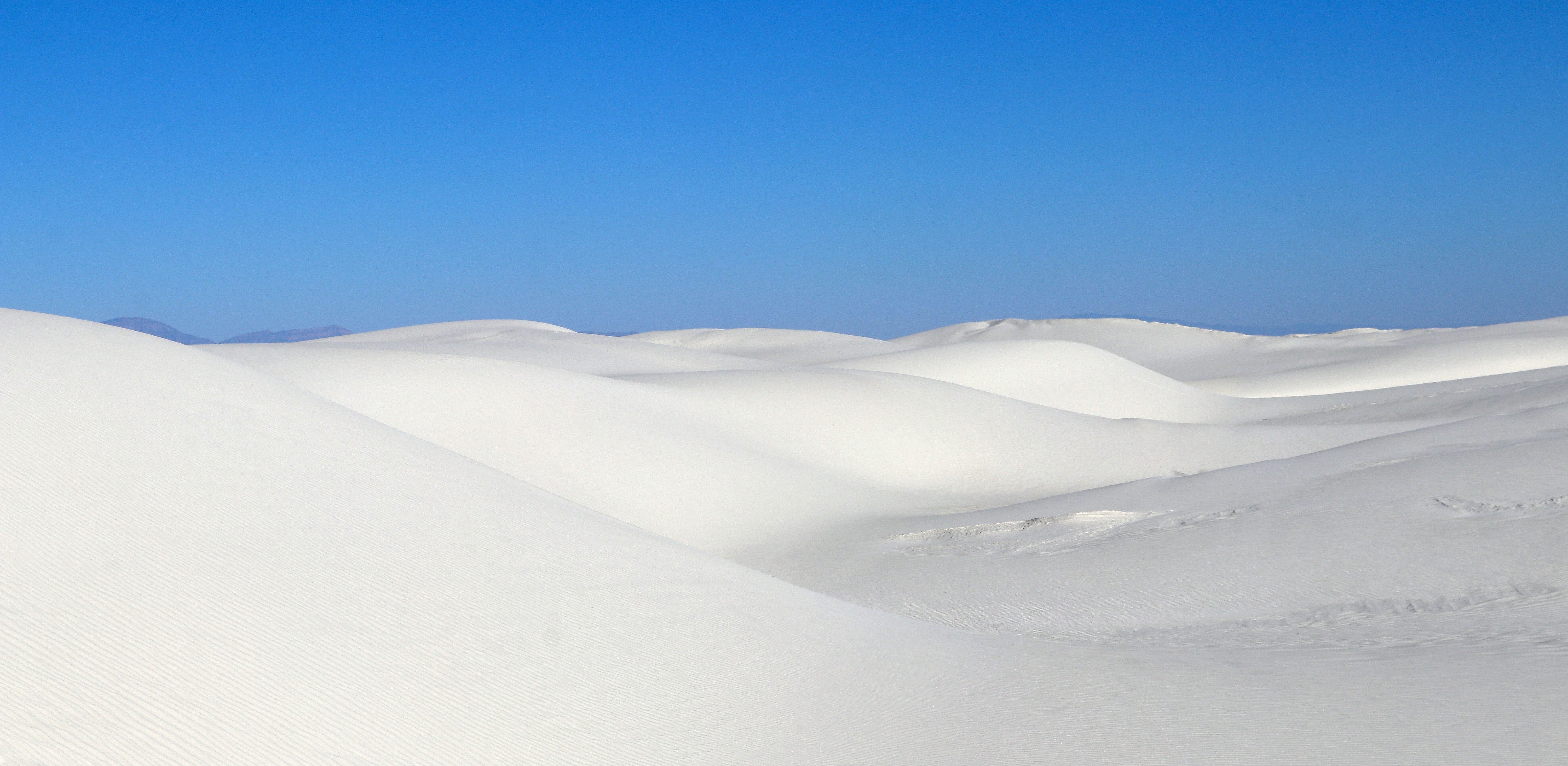 A person skiing down a snow covered slope photo – Free White sands ...