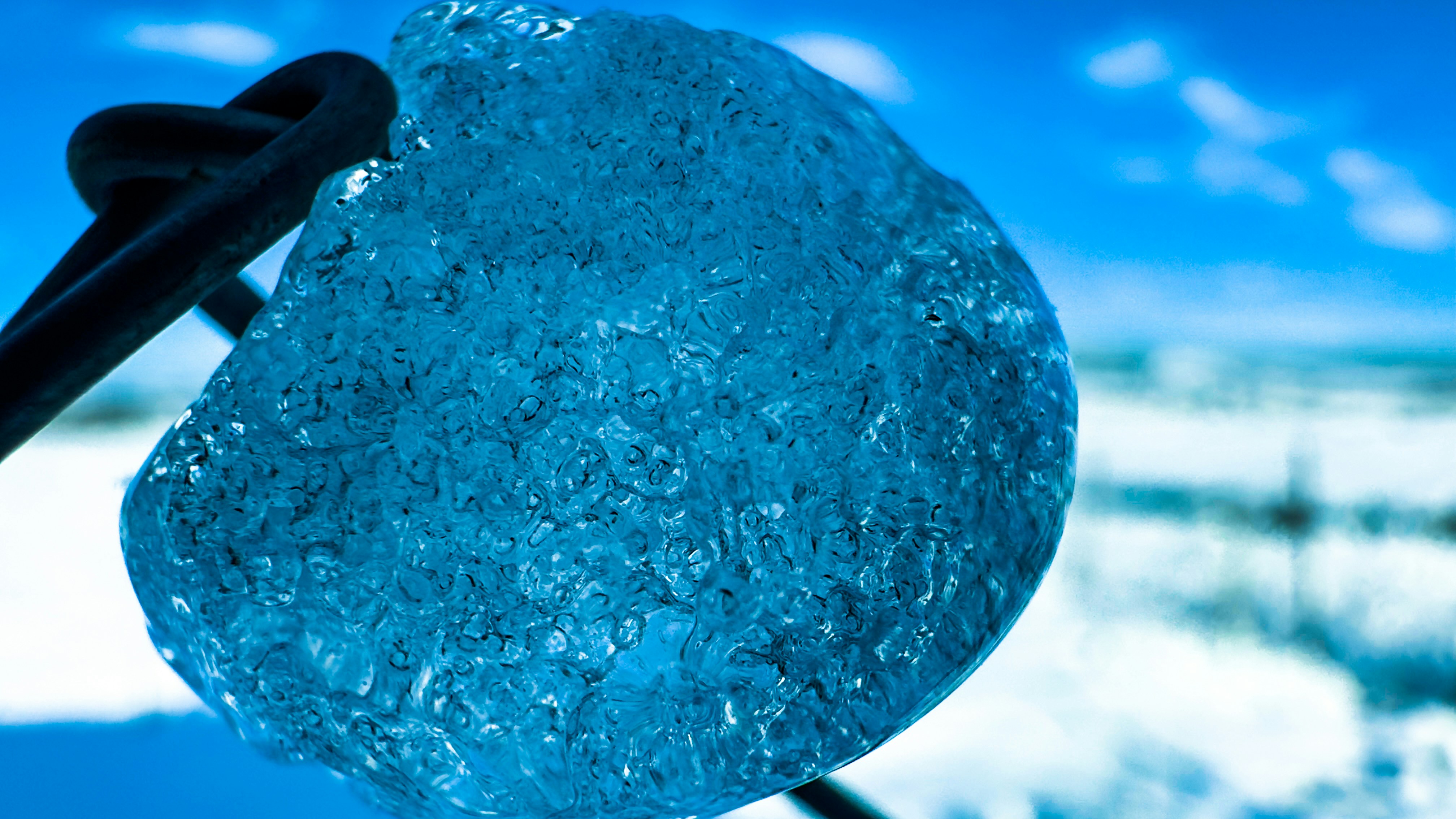 A close up of a blue ice ball hanging from a hook photo – Free Winter ...