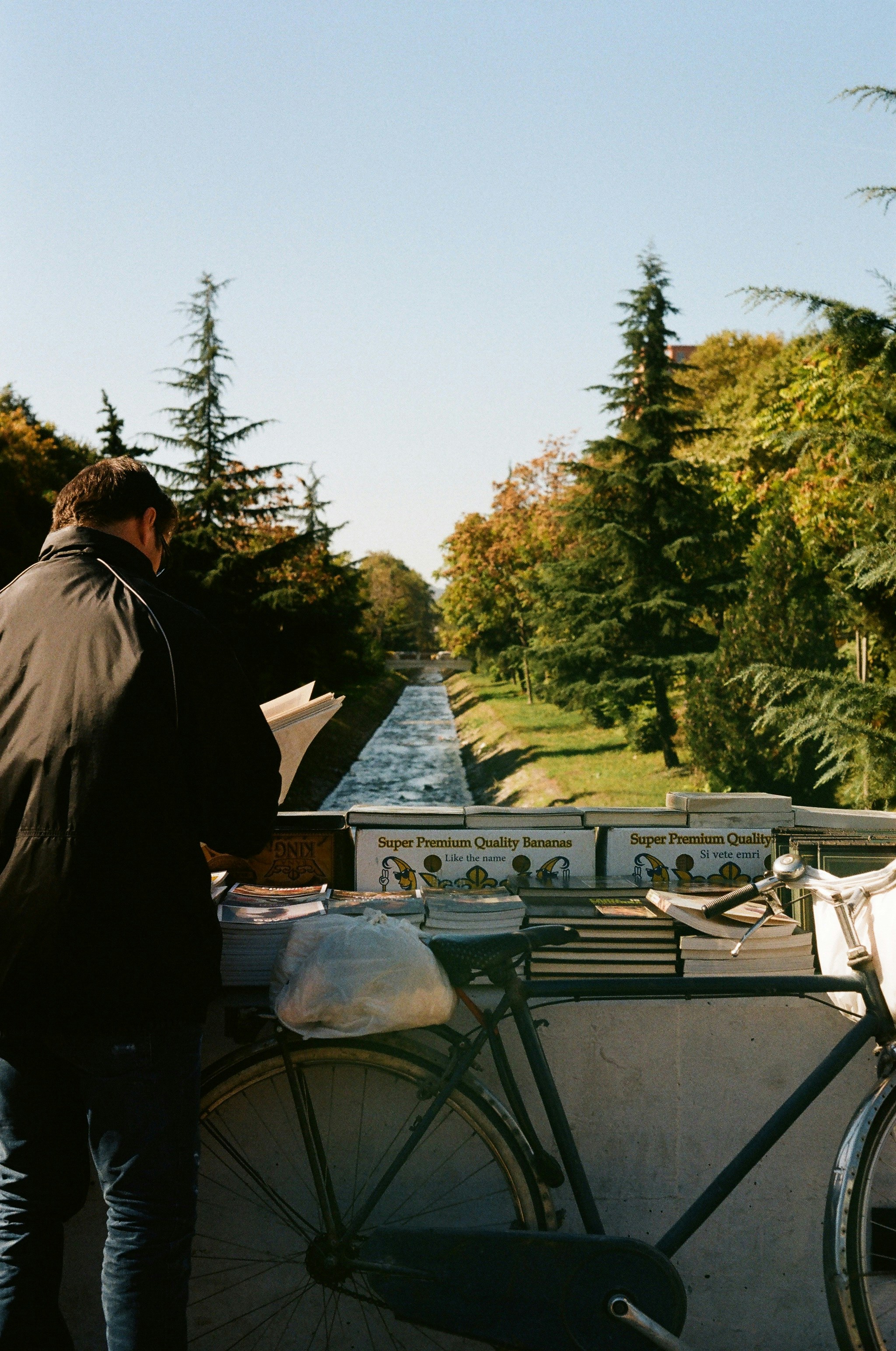 Vendor by the Canal: A Quiet Moment with a Bicycle Stall