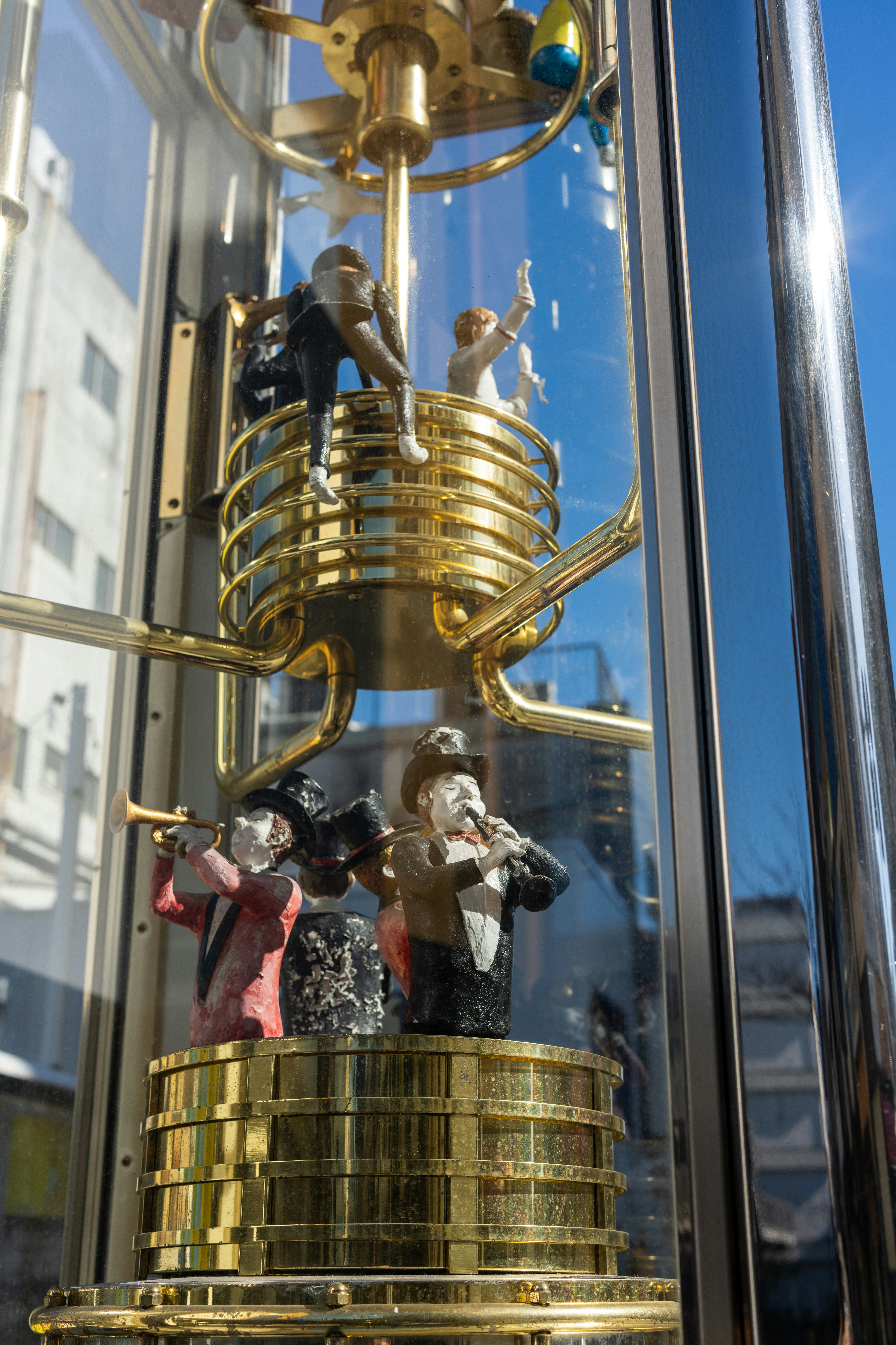Spiral Brass Serenade: Tiny Musicians in a Glass Case